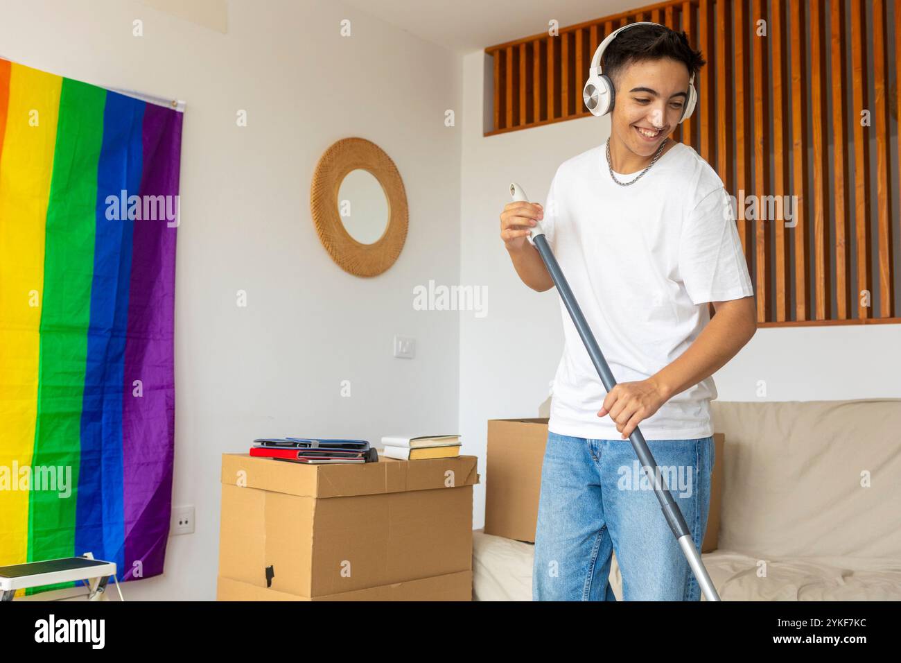 A cheerful trans man dances as he sweeps his new apartment, displaying ...