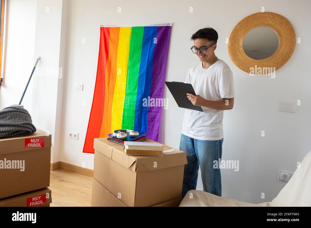 Cheerful trans man smiles while reading a document, surrounded by ...