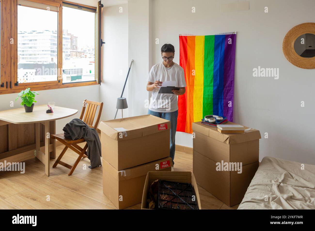 Cheerful trans man smiles while reading a document, surrounded by ...