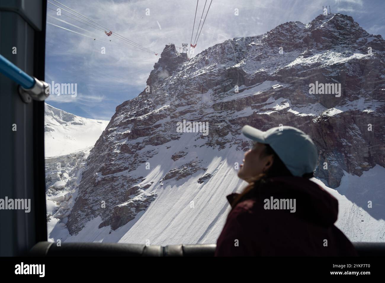 A traveler observes the impressive snow-capped peaks of Zermatt ...