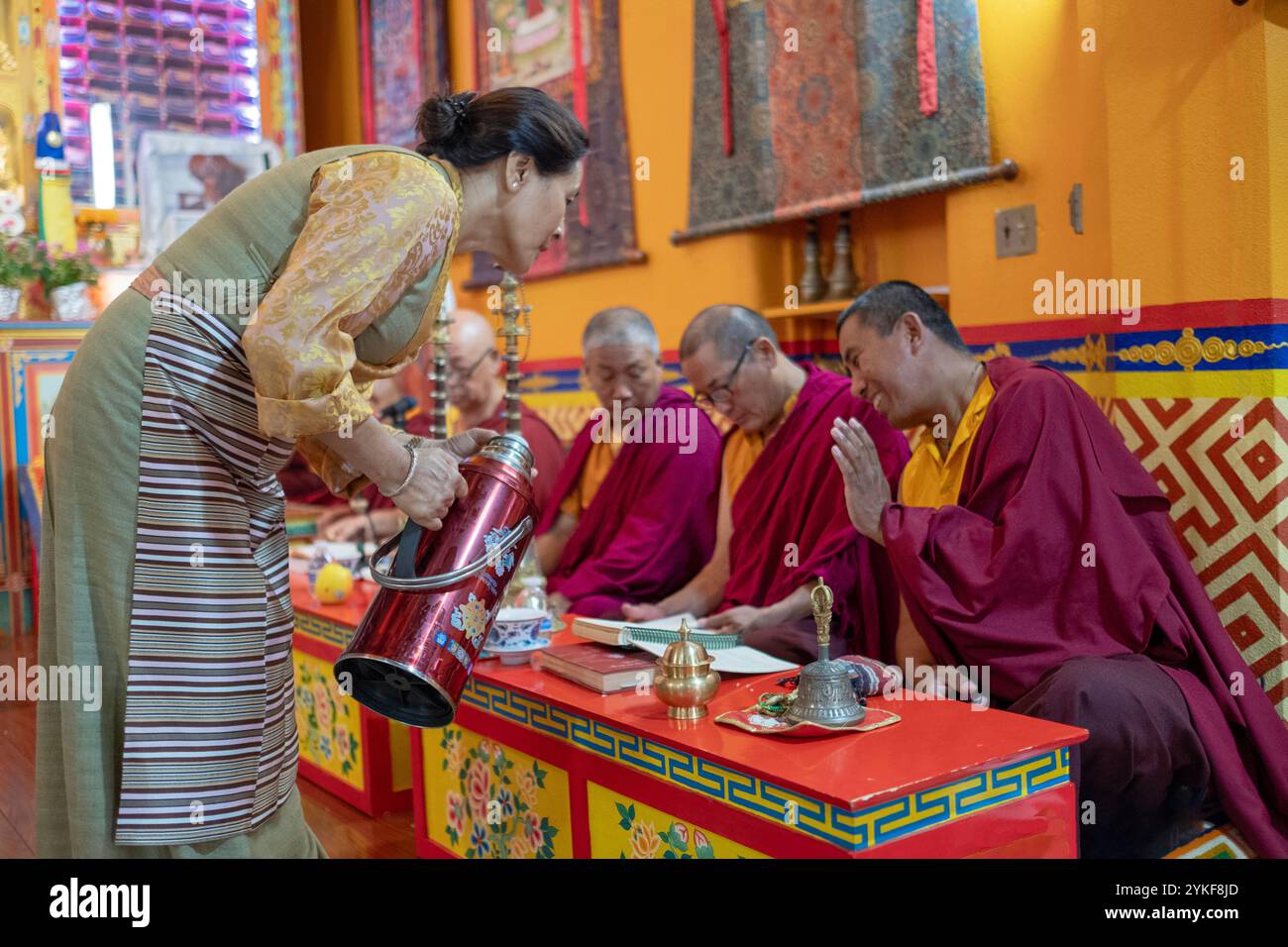 A Nepalese woman pours tea for the monks who are leading a morning ...