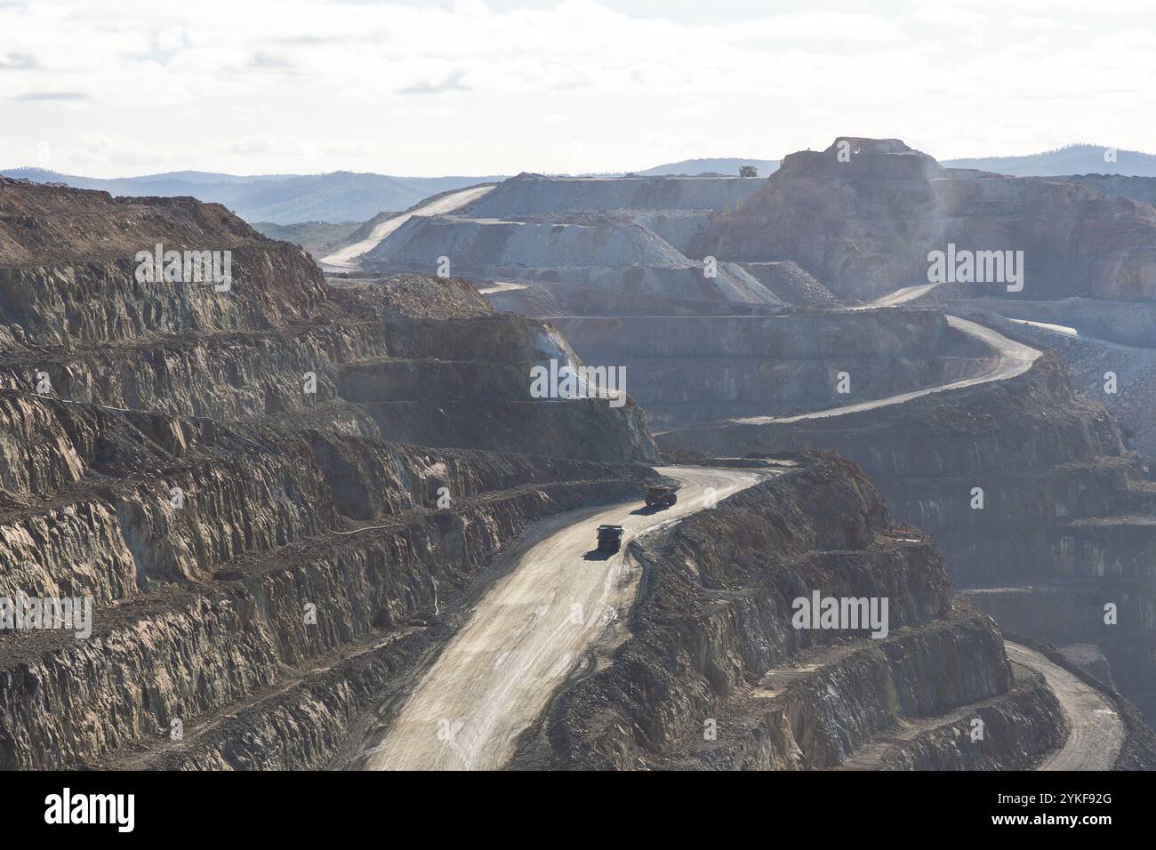 A truck navigates vast terraced layers of the Rio Tinto mine under a ...
