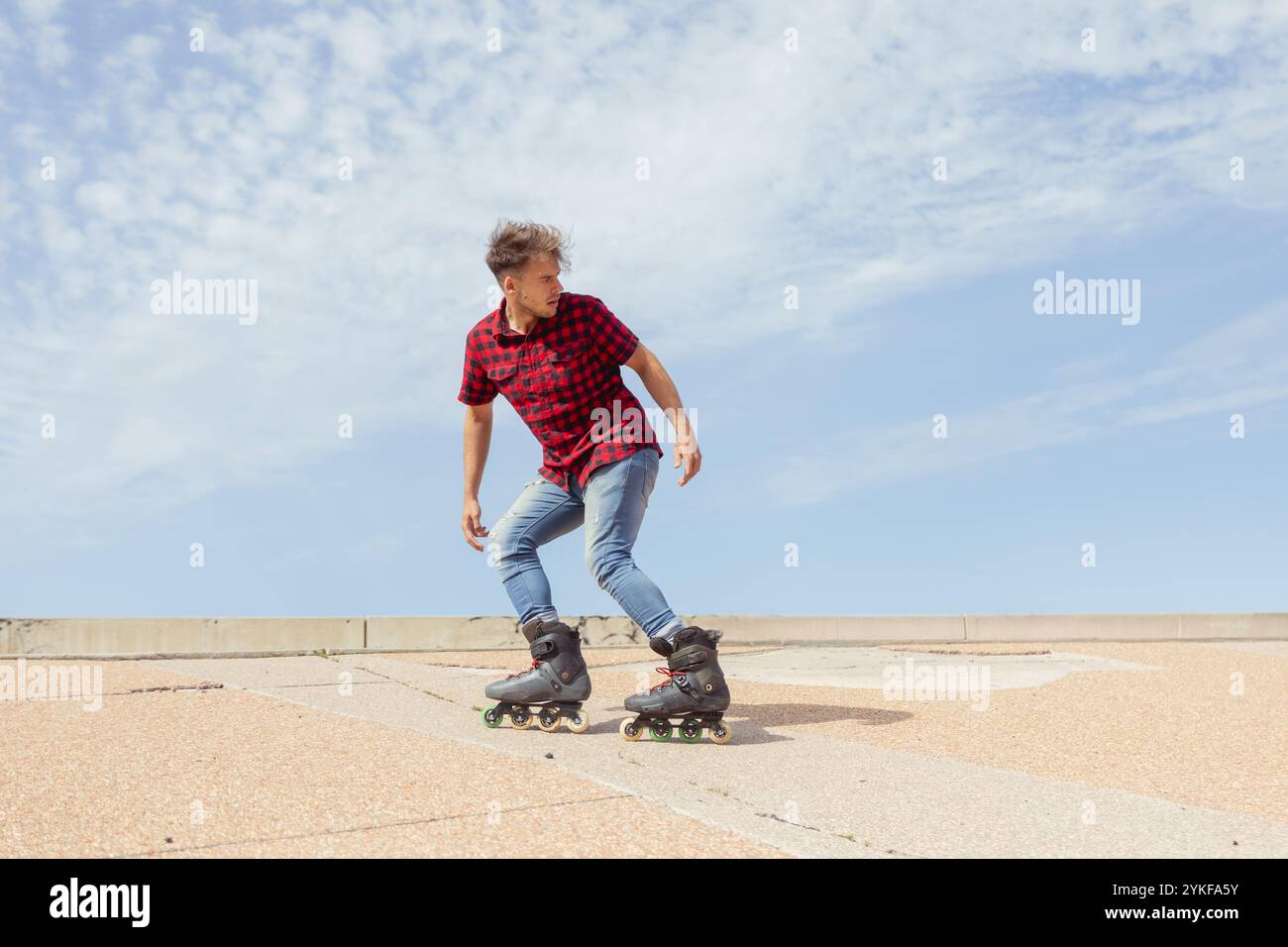 A young man actively rollerblading on inline skates, skillfully ...