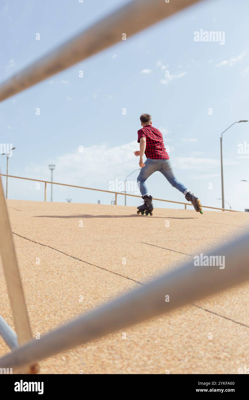 Back view of unrecognizable young man rollerblading on inline skates ...
