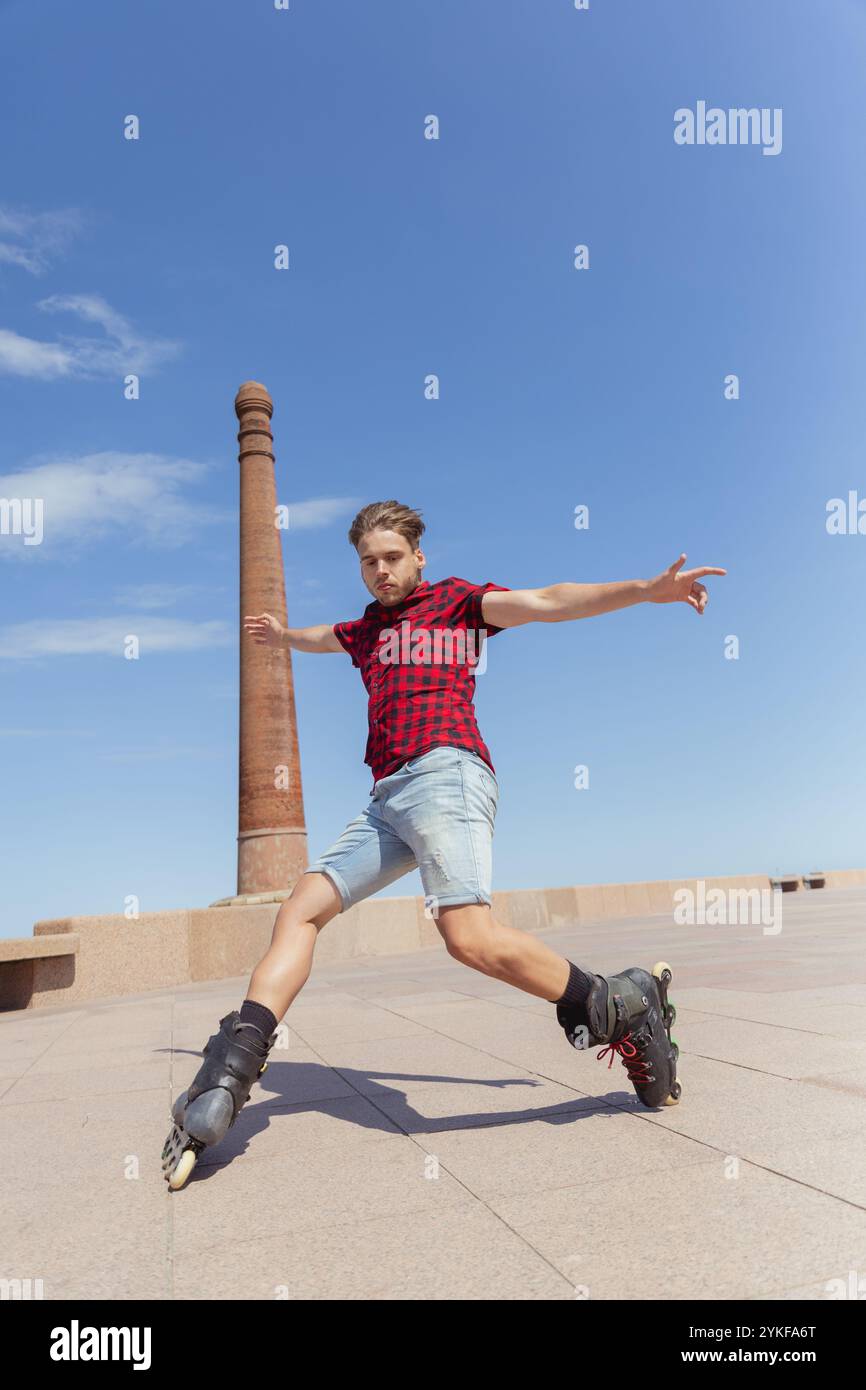 A young man showcases his rollerblading skills in an urban environment ...