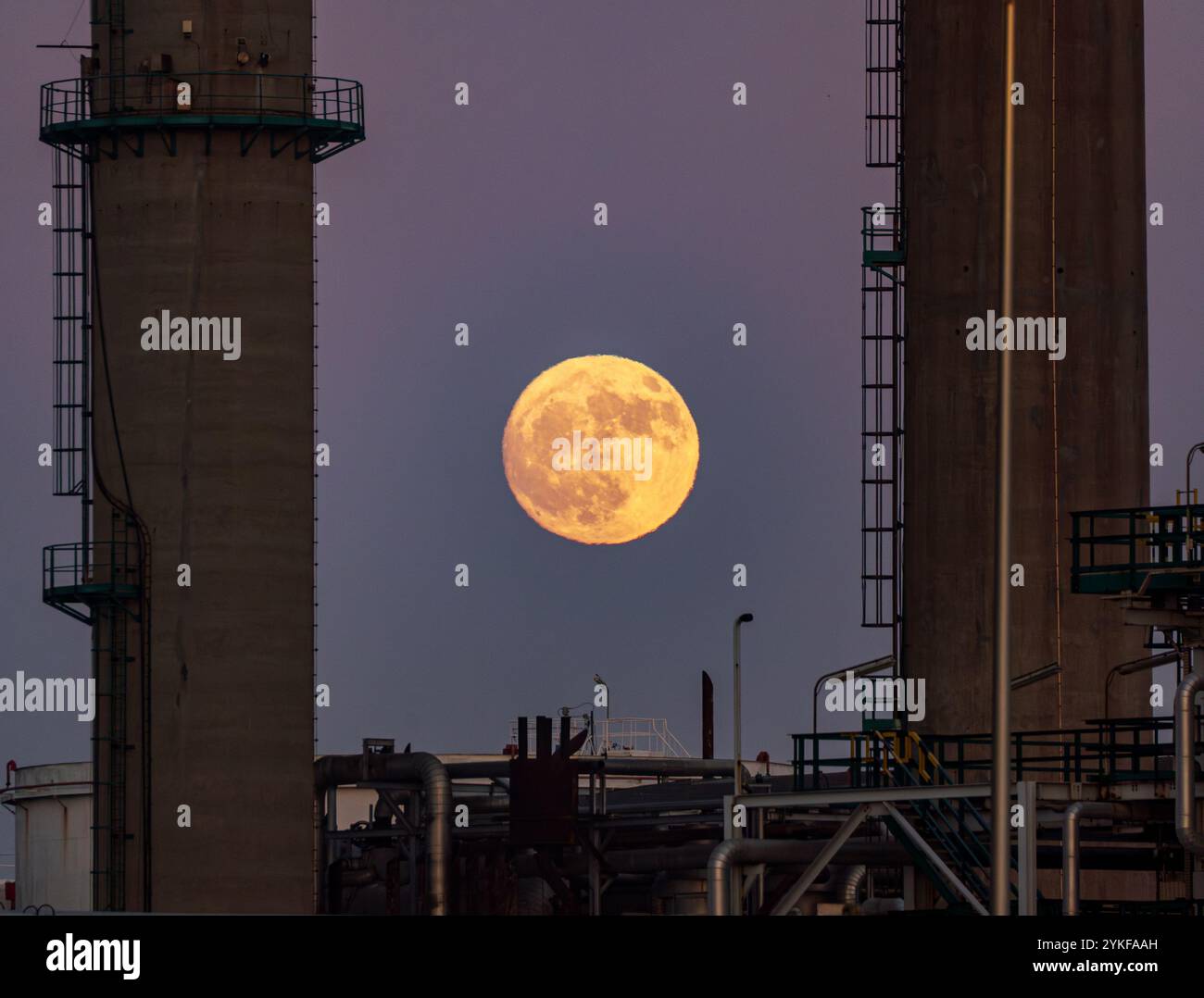 A striking full moon illuminates the twilight sky, rising above the ...