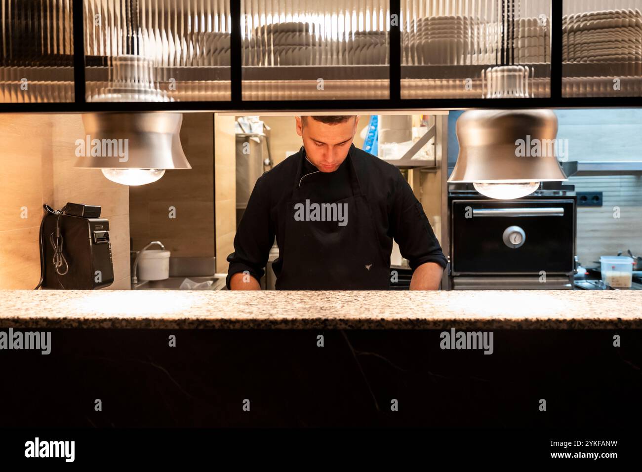 An expert chef meticulously prepares food in a modern restaurant ...
