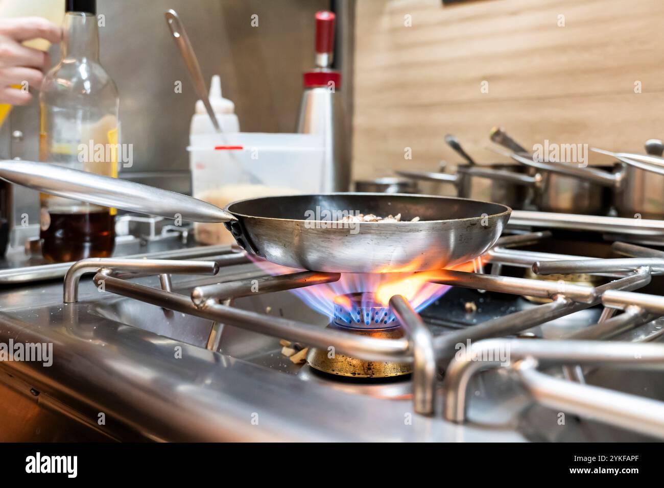Professional chefs deftly manipulate frying pans over high heat in a ...