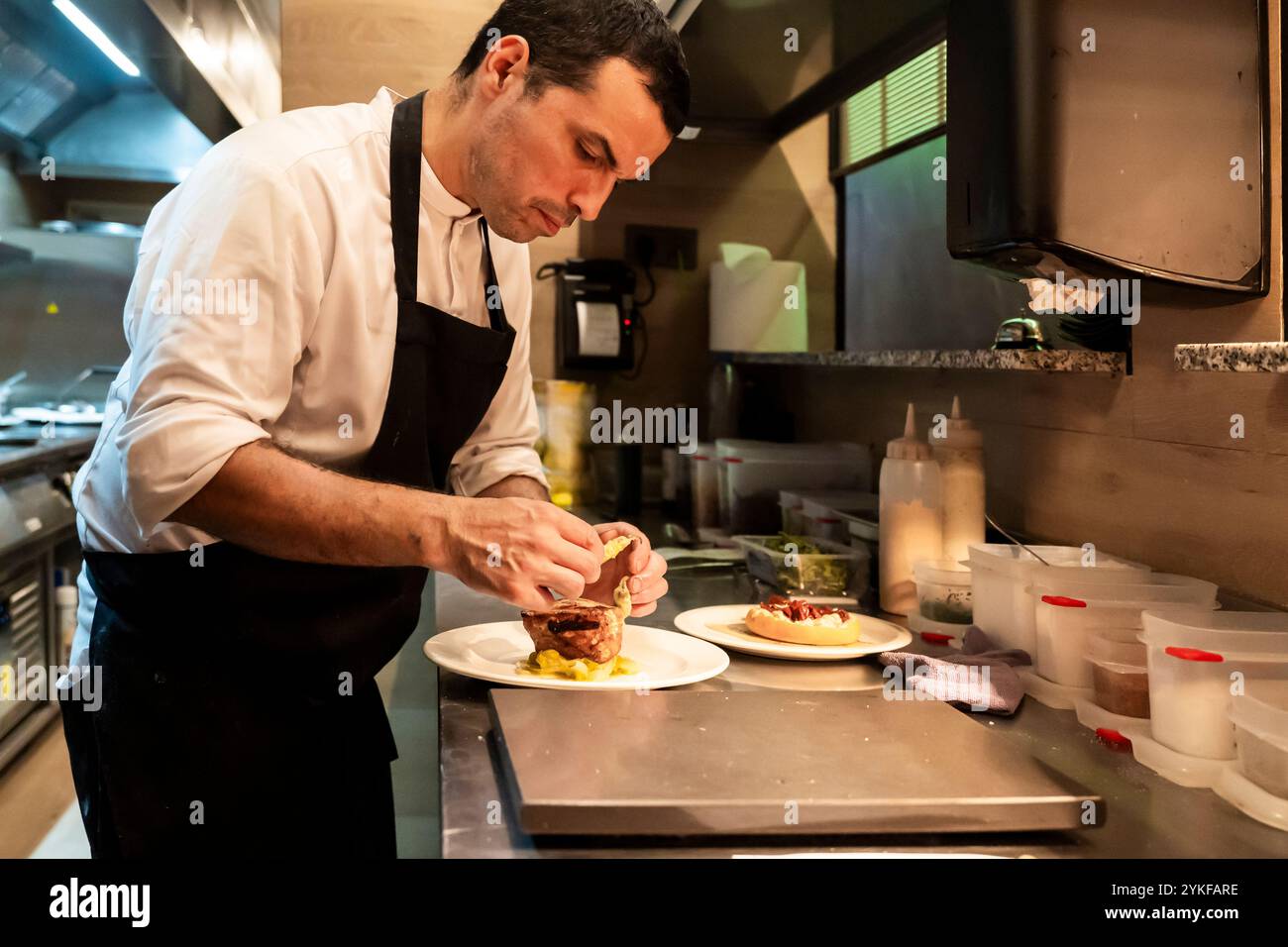 An expert chef plating a gourmet meal with precision in a bustling ...