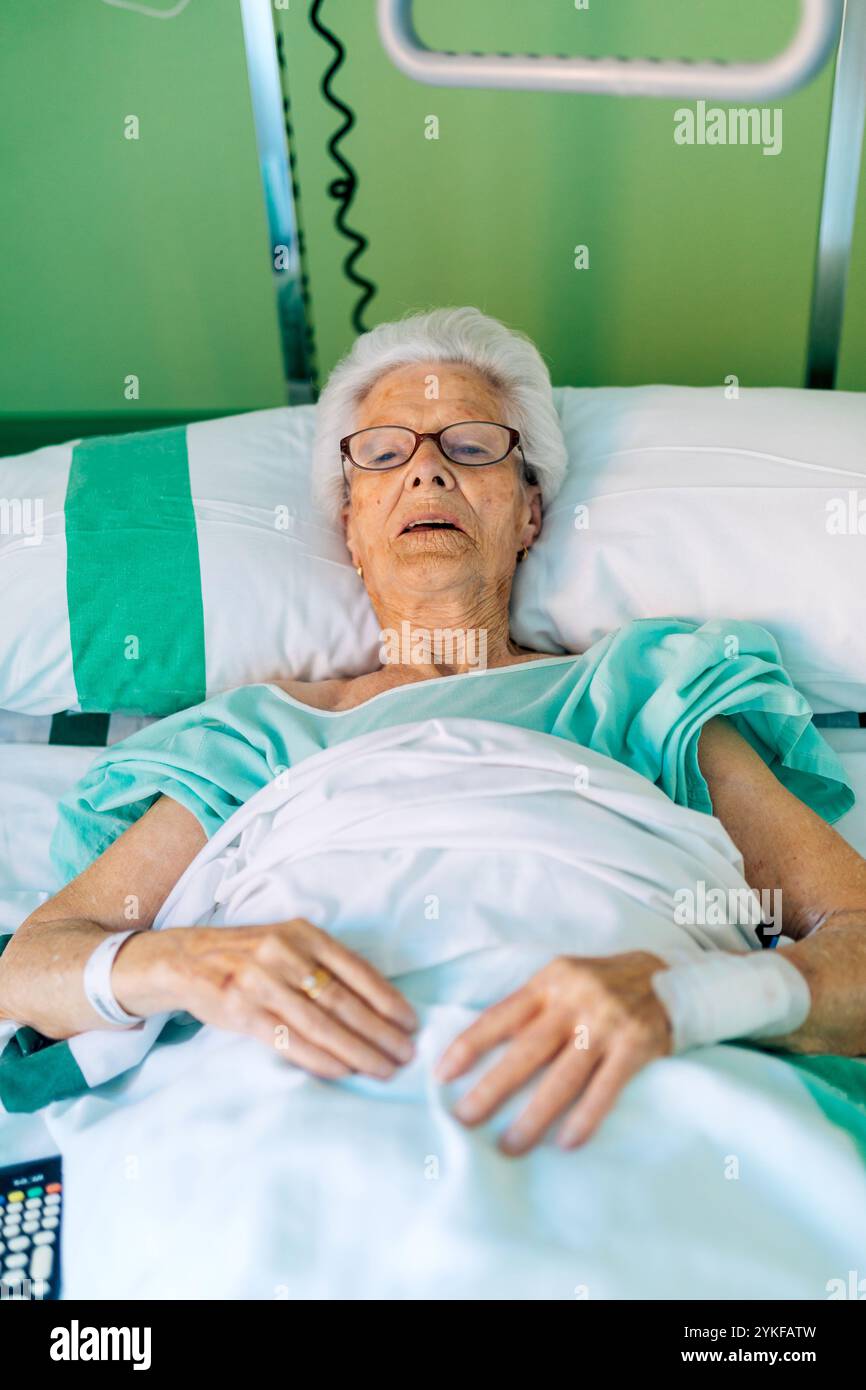 A senior woman lies in a hospital bed, appearing calm and relaxed She ...
