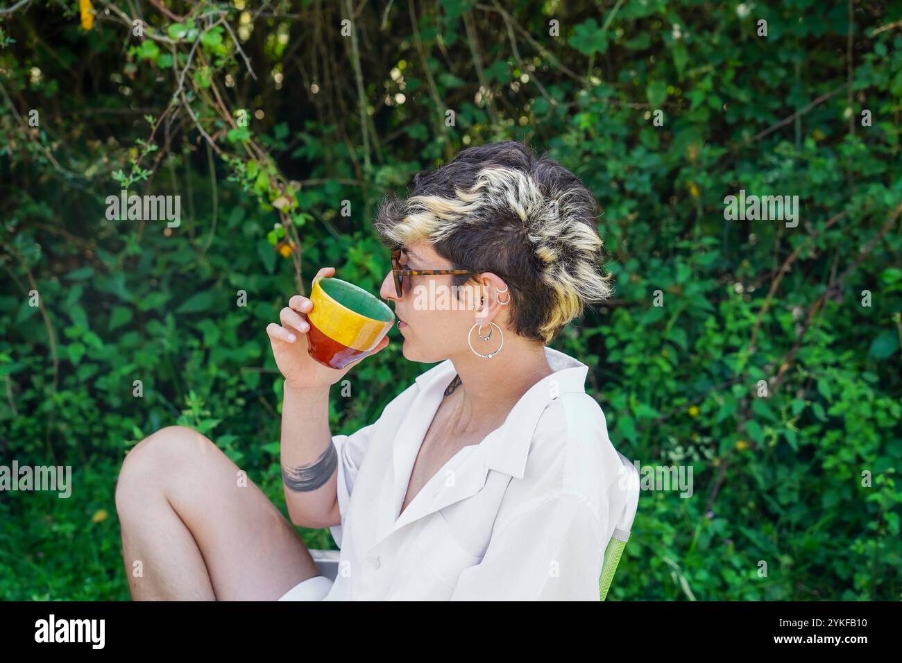 A non-binary individual with a stylish haircut and casual attire ...