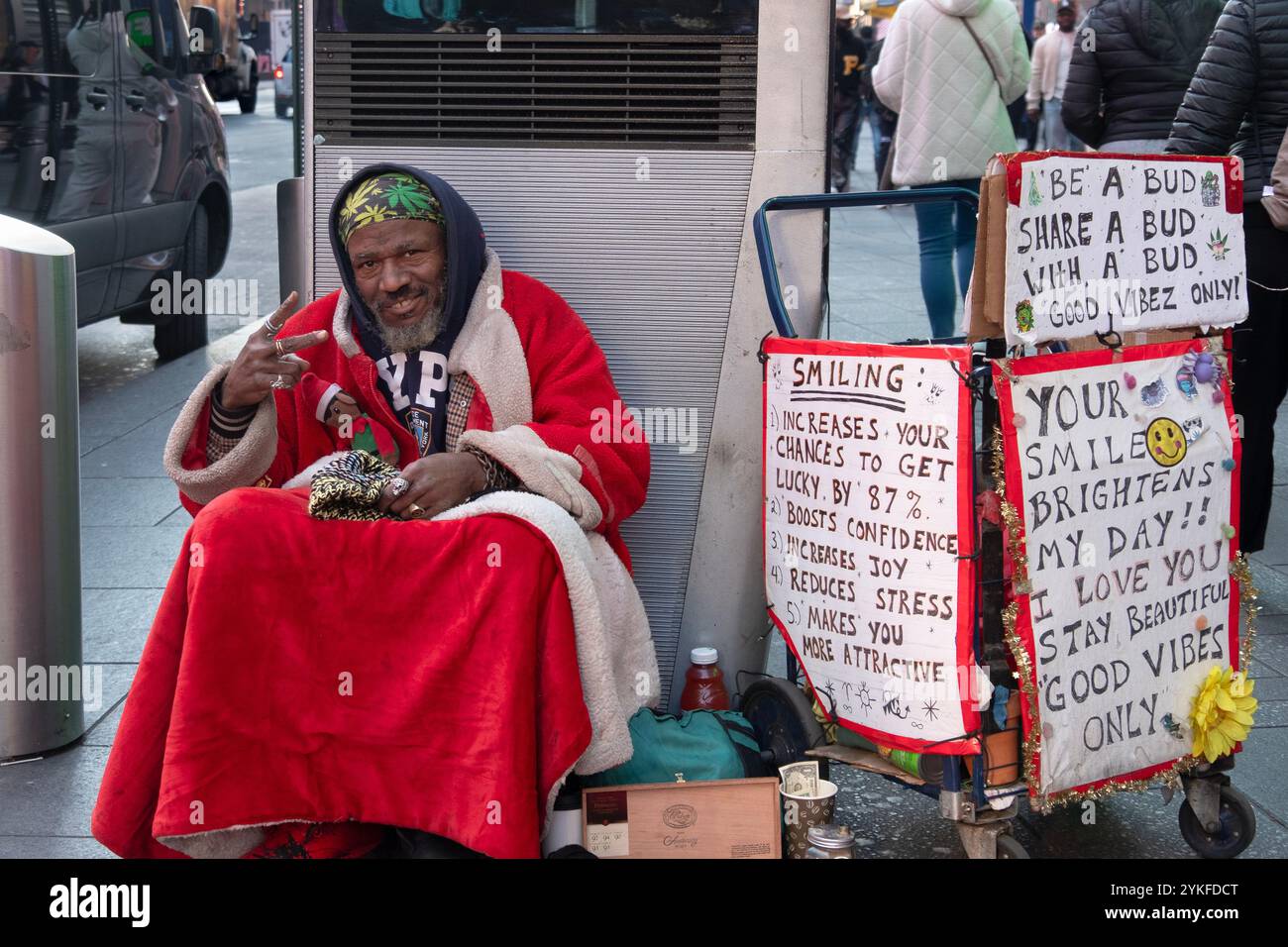 Posed portrait of a man seated in Times Square with signs encouraging ...