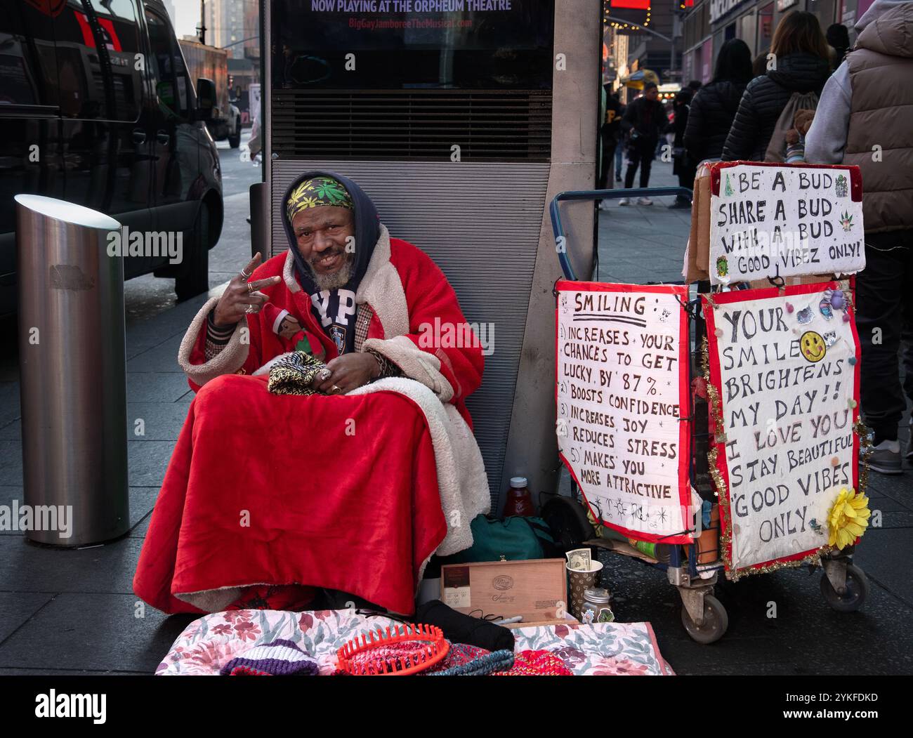 Posed portrait of a man seated in Times Square with signs encouraging ...