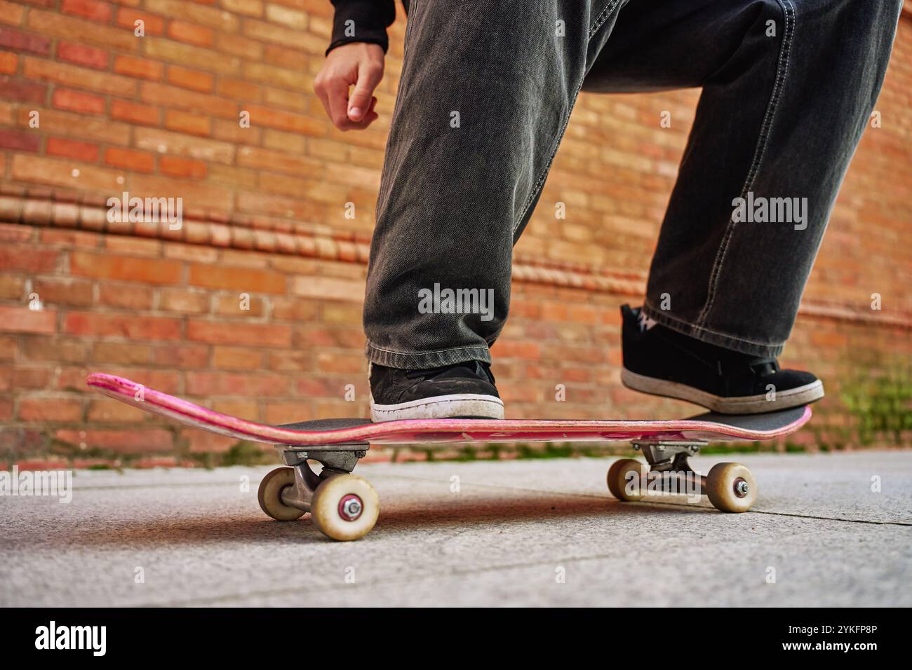 Skateboarder doing trick at urban street. Close up of skater wearing ...