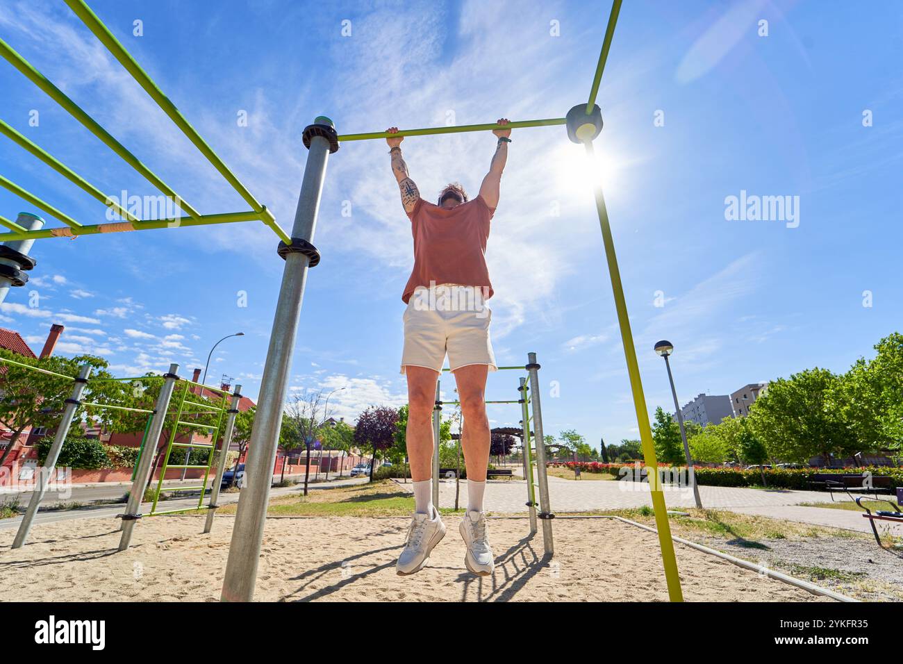 A man engages in a vigorous workout session at an outdoor calisthenics ...