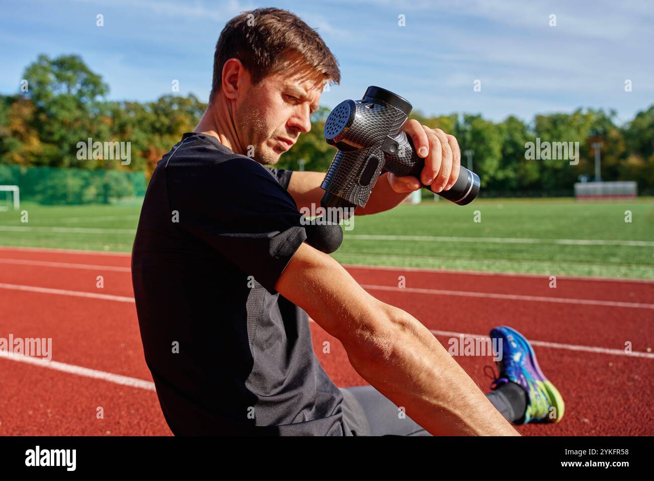 Athlete using handheld massage gun hi-res stock photography and images ...