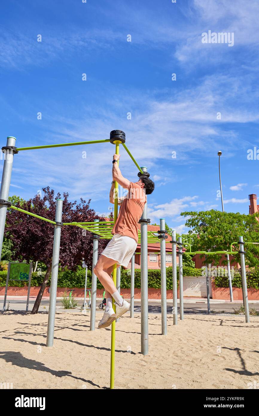 A man engages in a vigorous workout session at an outdoor calisthenics ...