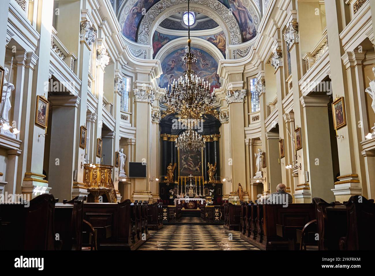 Interior of catholic church with wooden pews and altar in background ...