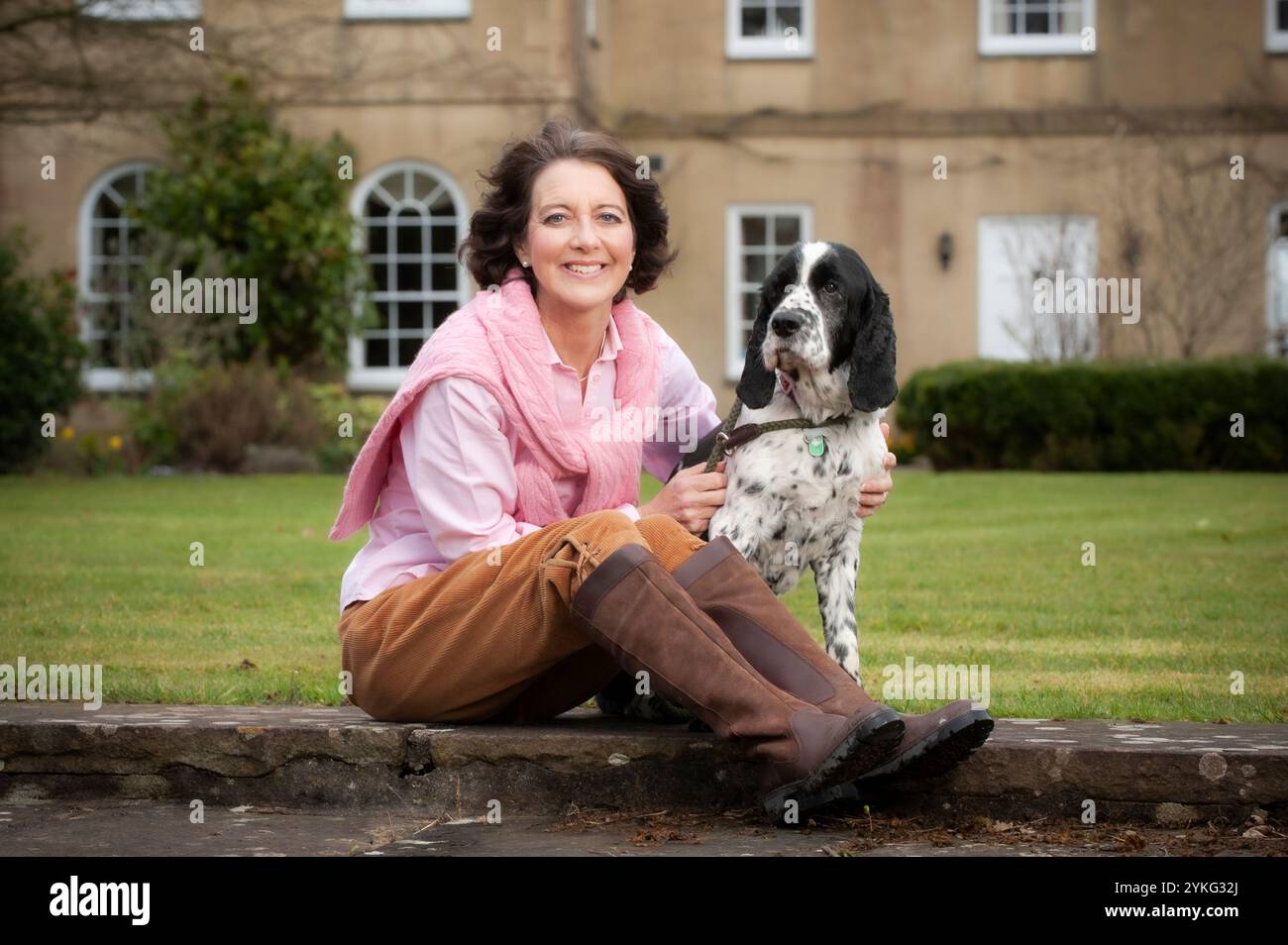 A middle aged woman sat petting her elderly cocker spaniel dog Stock ...