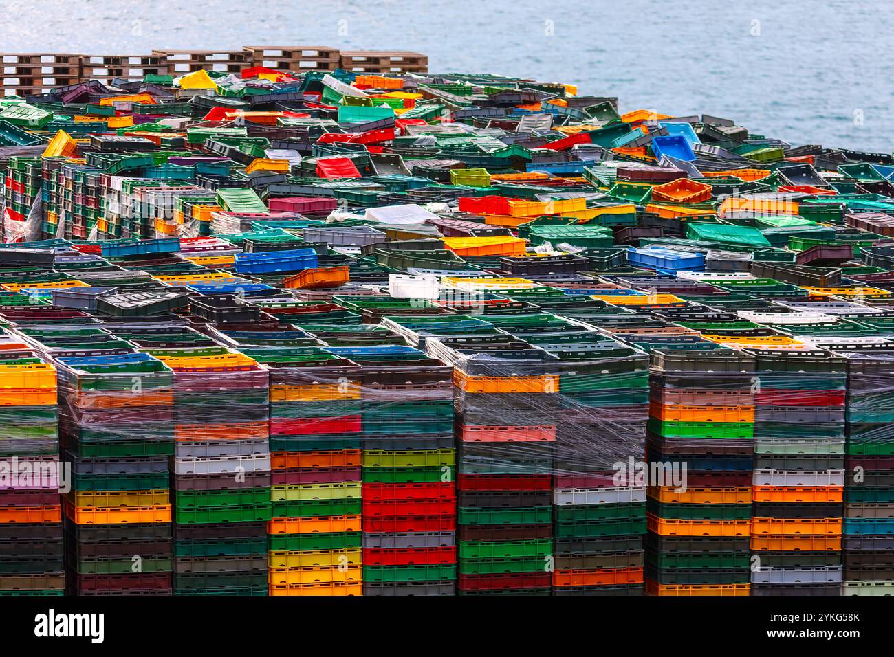 Large number of stacked plastic crates in various colors. Crates are ...