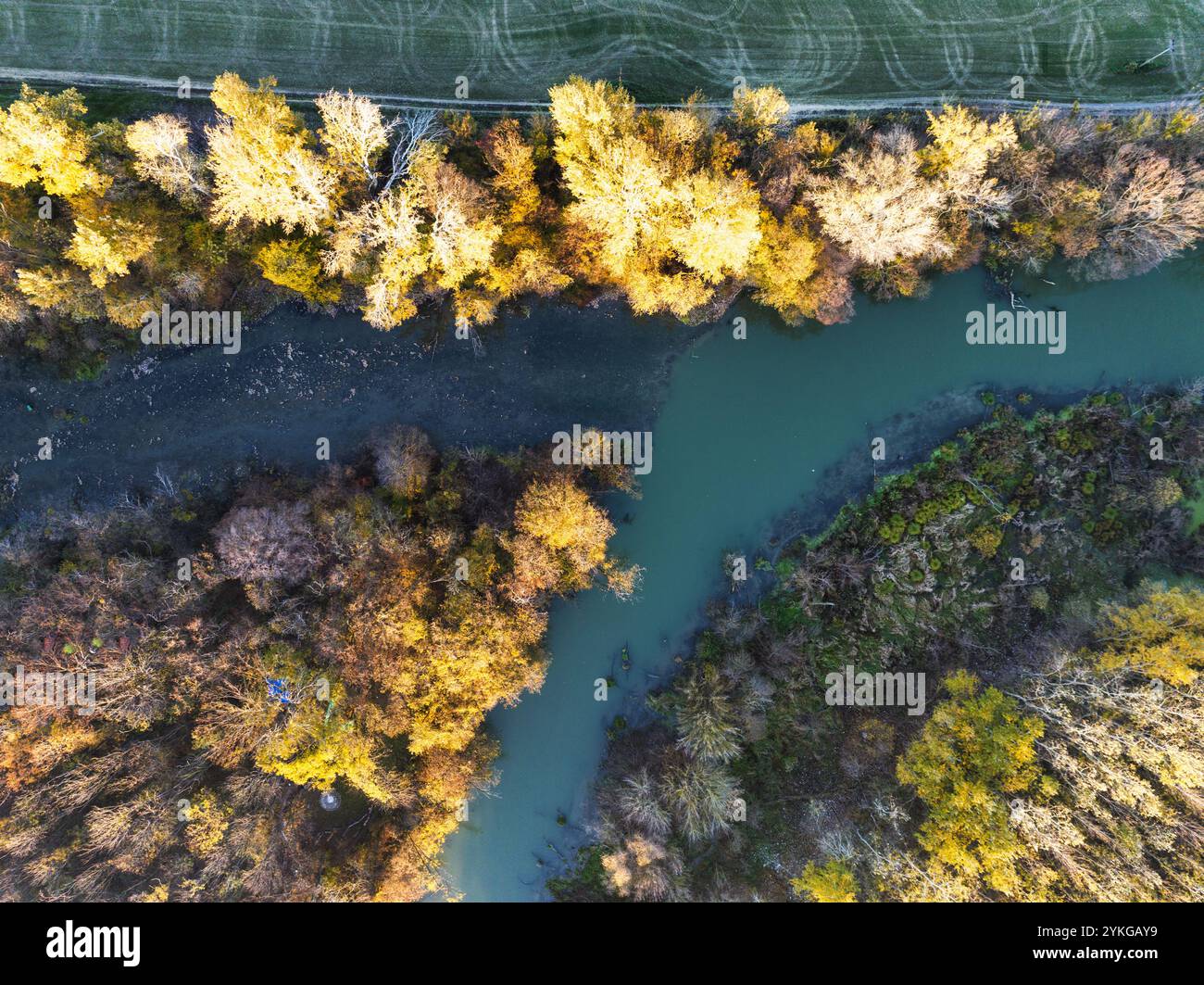 Aerial landscape yellow autumn forest with meander small winding river with sun light, top view ...