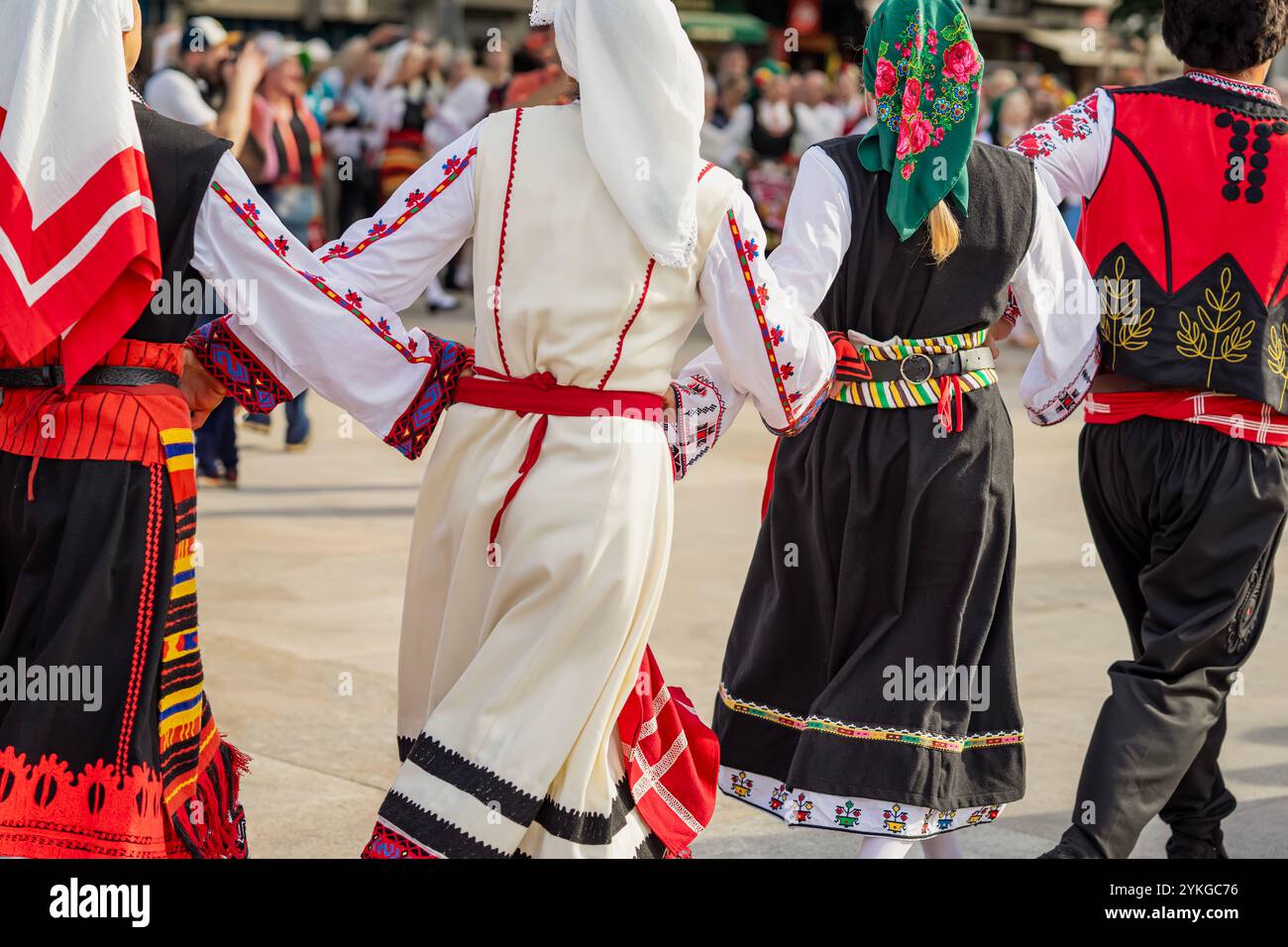 Group dancing hand-in-hand folk dance in traditional embroidered ...