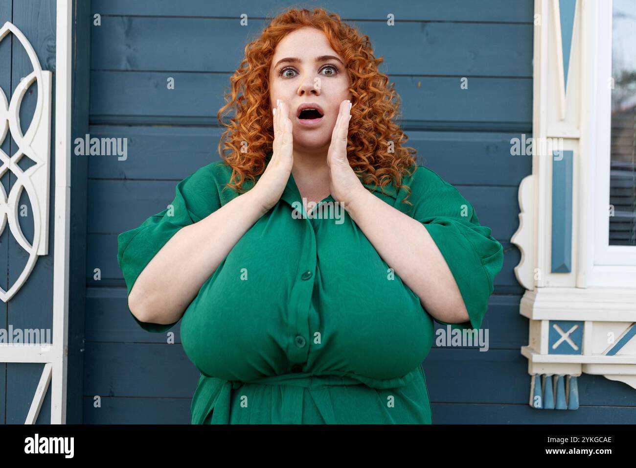 Surprised Plus Size Woman with Curly Red Hair in Green Clothing Against ...