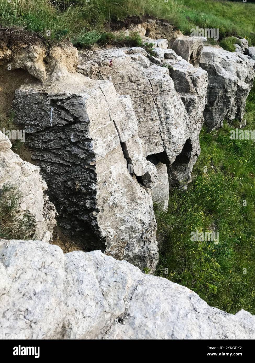 A natural cliff edge showcasing exposed rock formations and lush ...