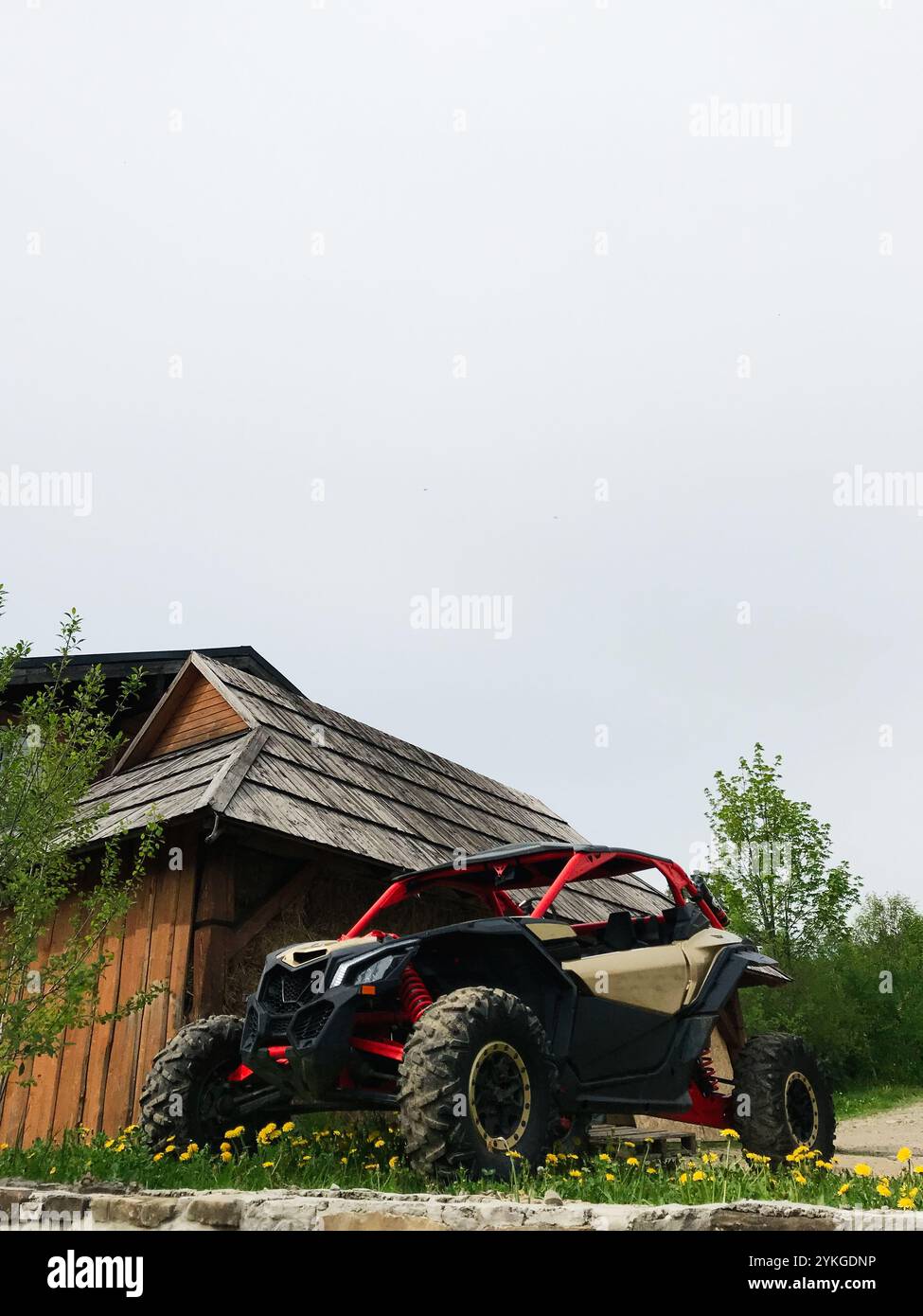 An off-road vehicle is parked near a rustic cabin amidst lush greenery ...