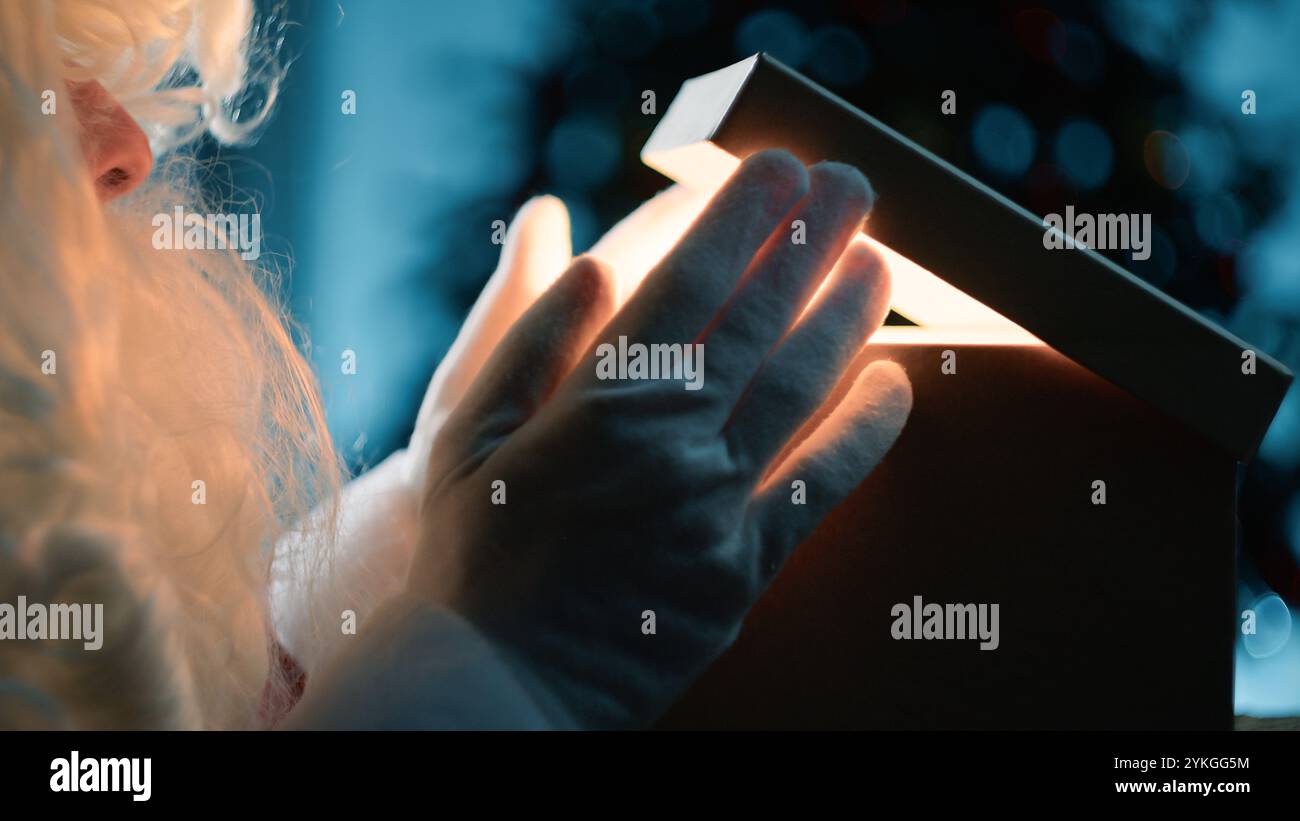 Santa Claus peeks inside the Christmas gift Box Stock Photo - Alamy