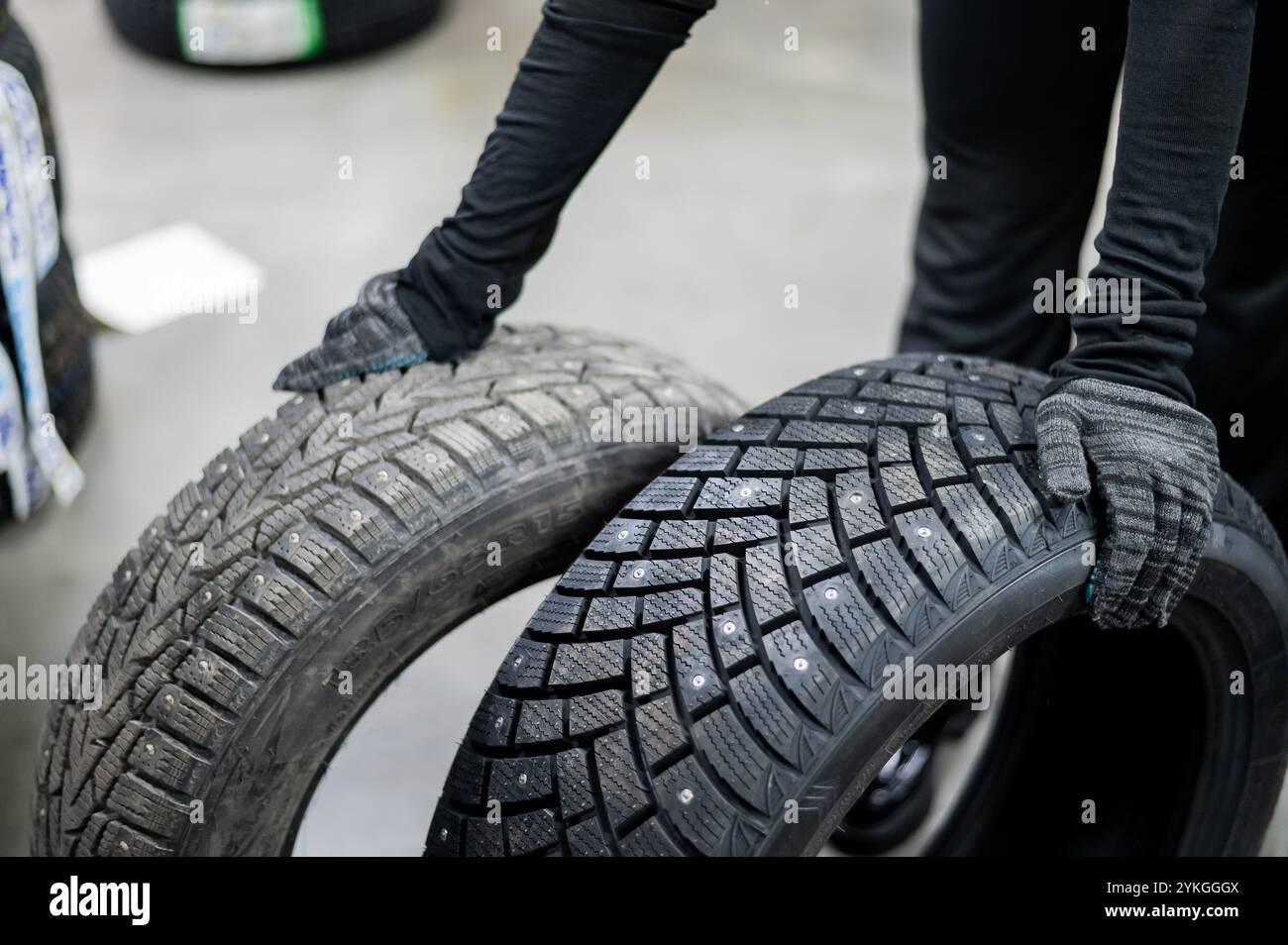 Mechanic keeps new summer and winter car tires in the garage. Comparison of wheels for different ...