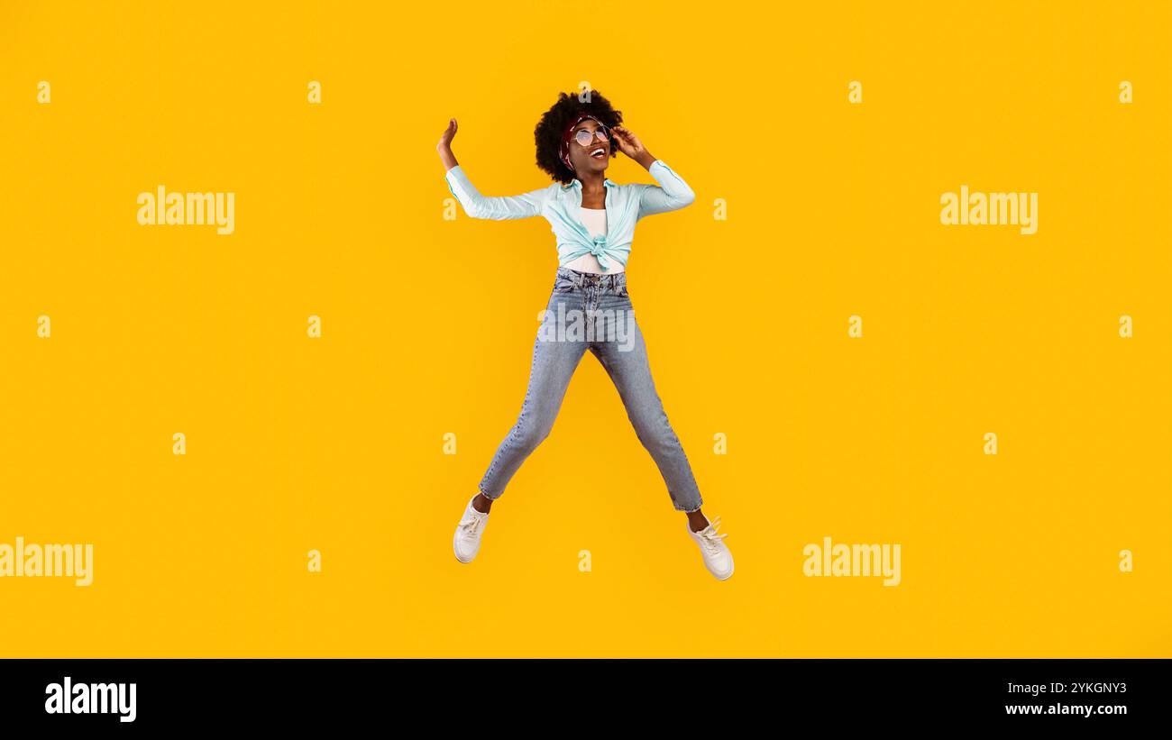Joyful African Woman Jumping Wearing Sunglasses Posing Over Pink ...