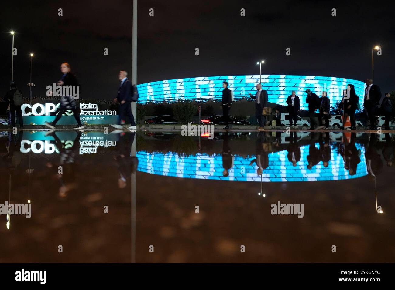 People walk with the Baku Olympic Stadium in the background, the venue ...