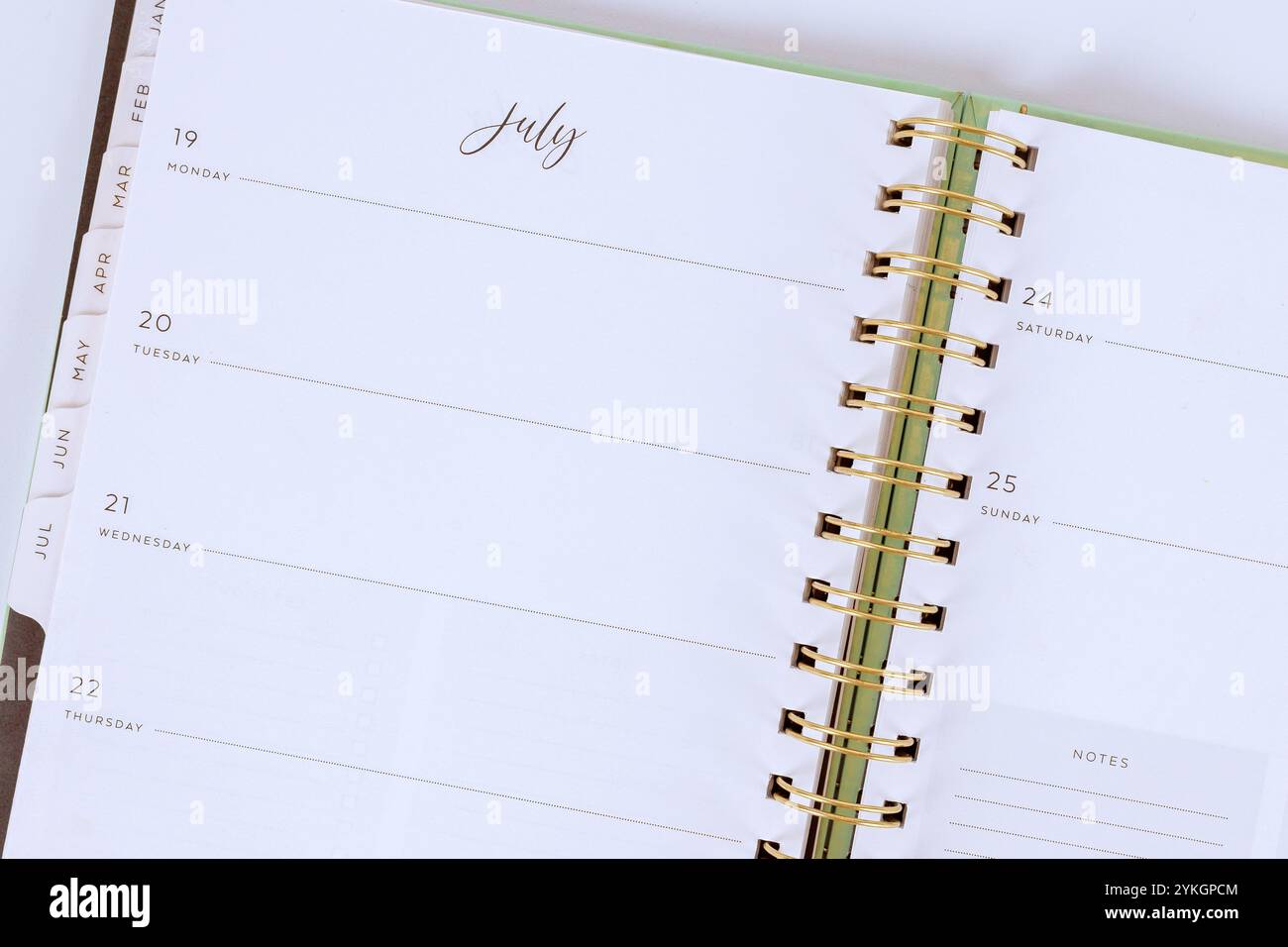 Planner opened to month of July shows empty weekly sections, providing ...