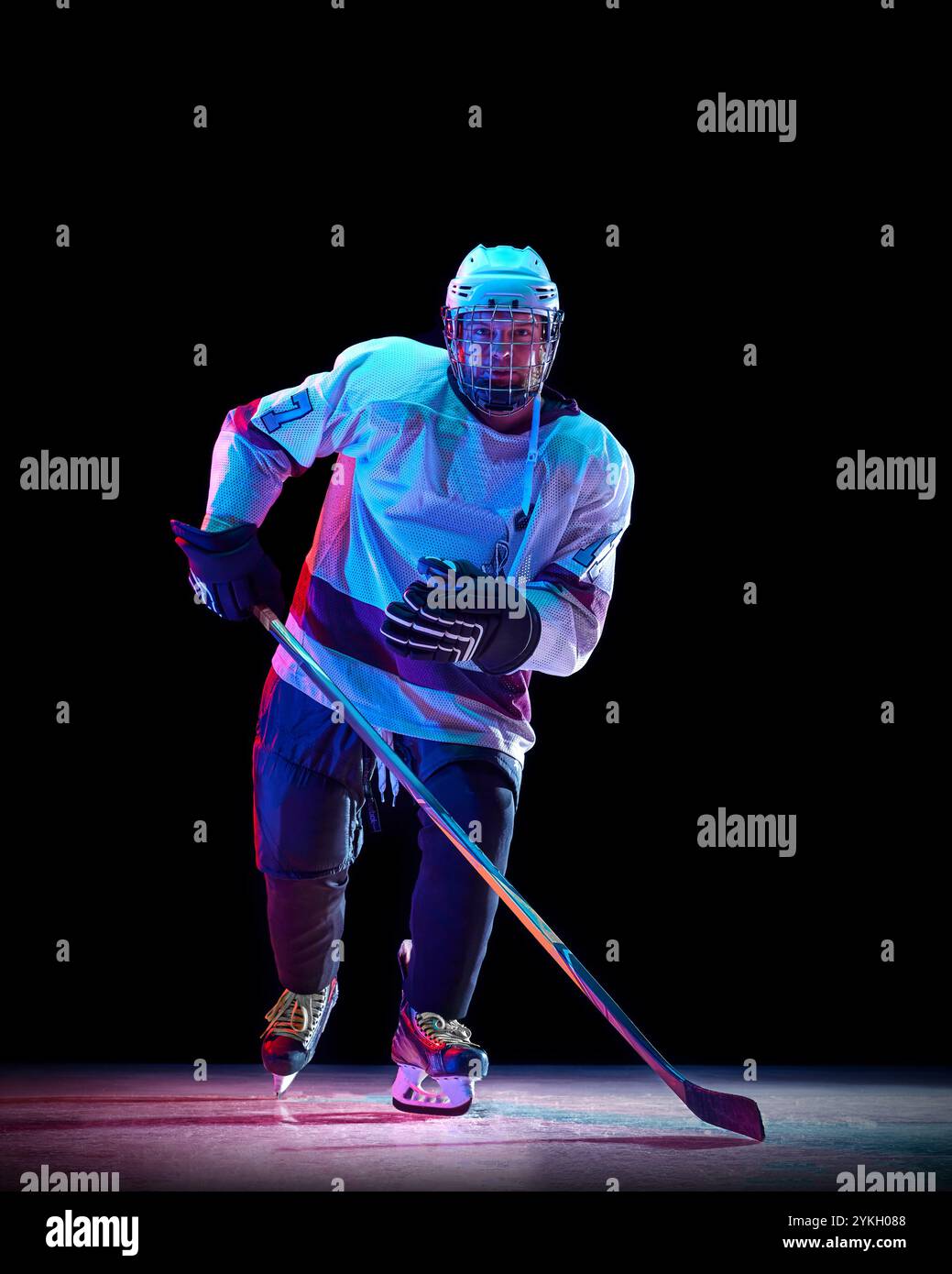 Dynamic image of competitive men's, hockey player in white sportswear ...