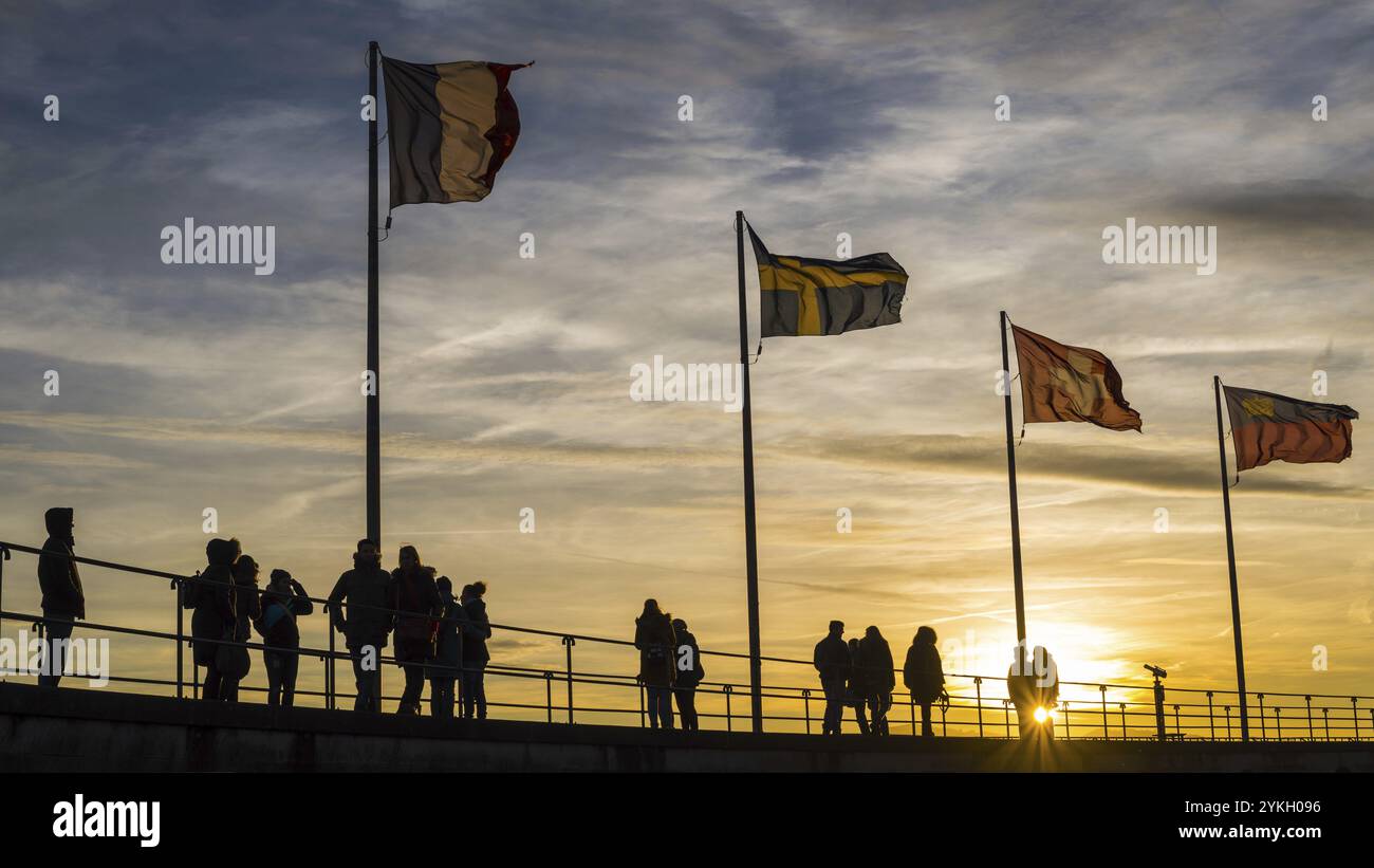 People, silhouettes, flags, harbour in Lindau on Lake Constance ...