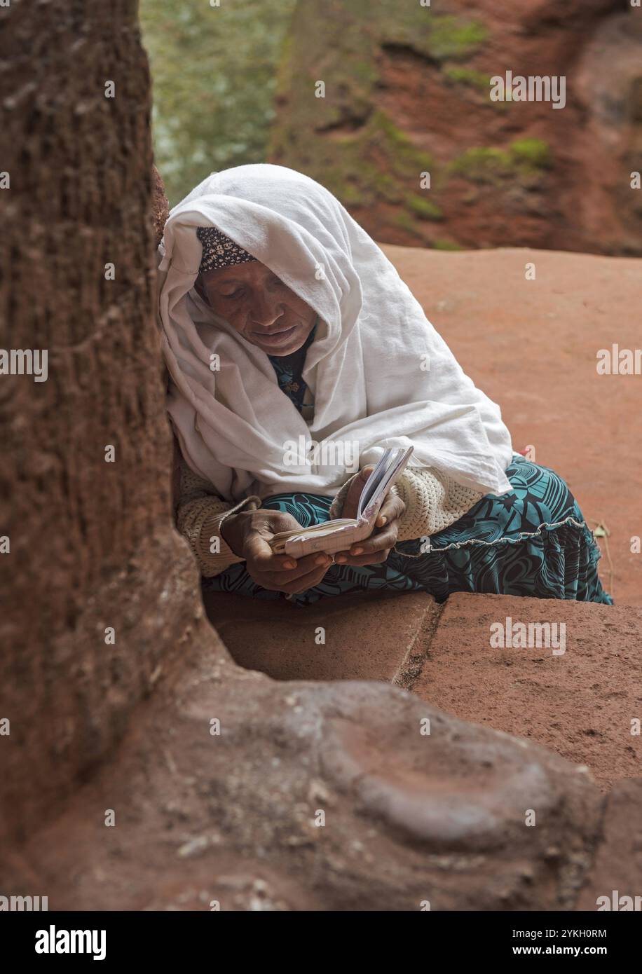 Ethiopian Orthodox believers absorbed in prayer at the entrance to the ...