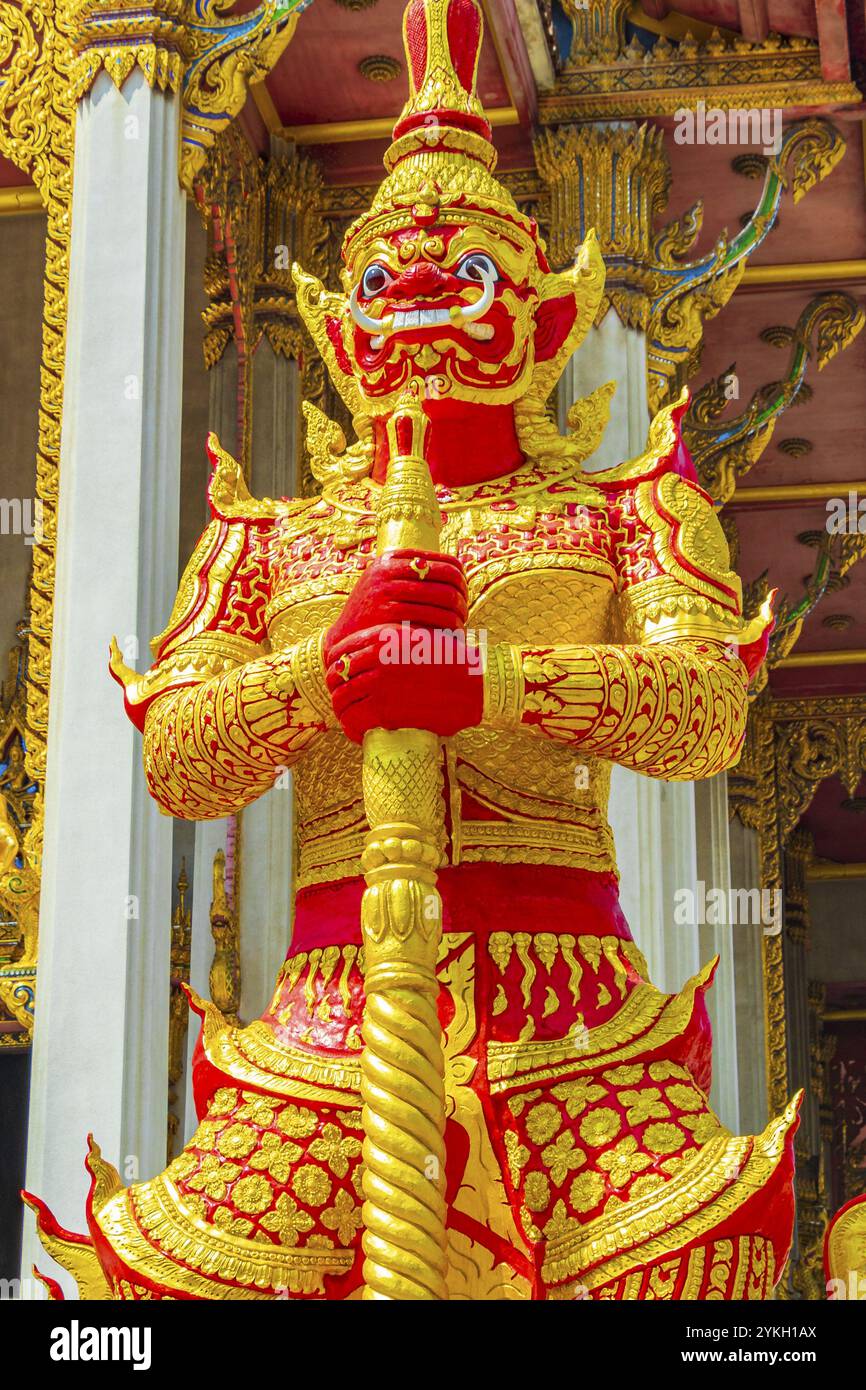Giant temple guardian Yaksha in gold red at colorful Wat Don Mueang ...