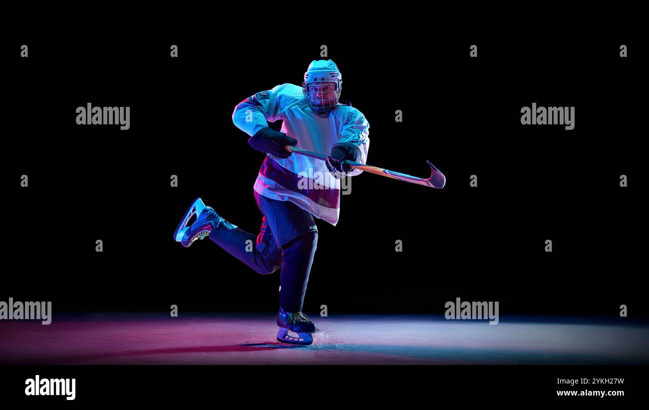 Competitive man, hockey player wearing full game gear, in motion with ...