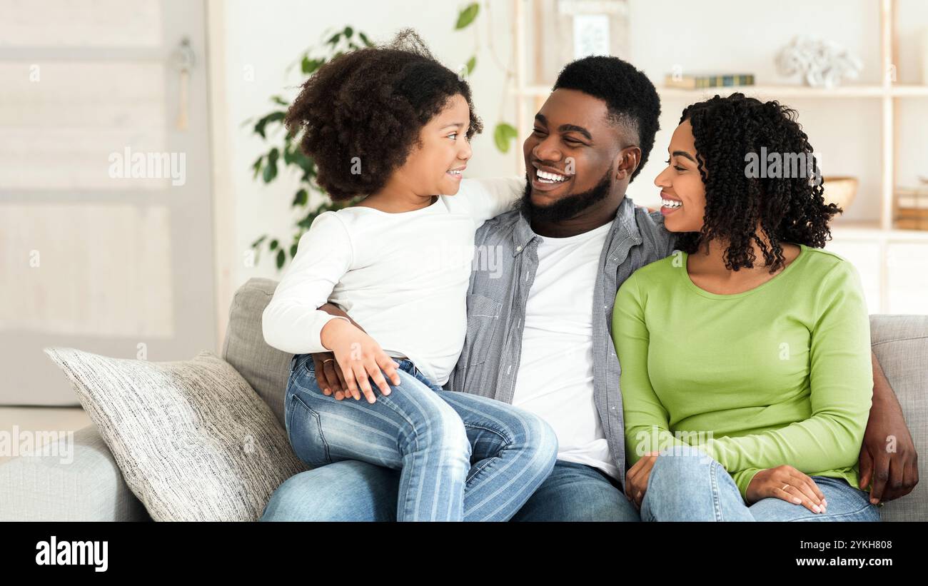 Happy African American Parents Bonding With Their Little Daughter At ...