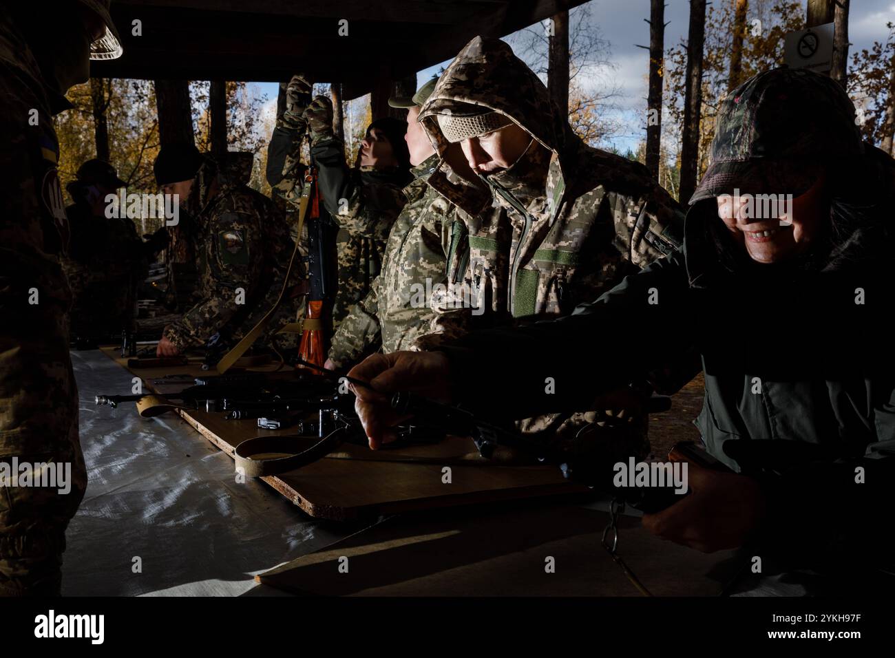 A group of women in military uniform receive instruction in the use of ...