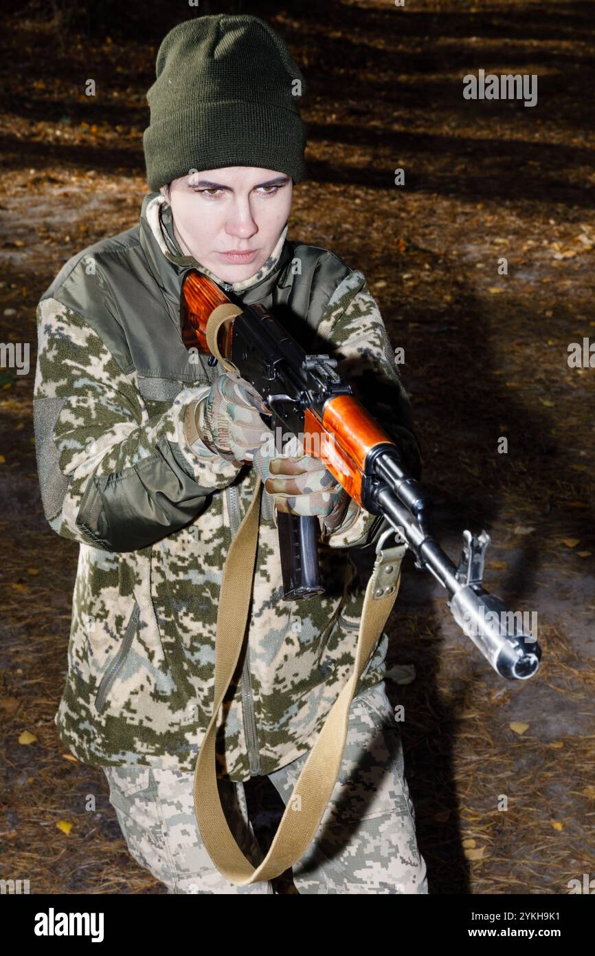 A young woman is seen holding a machine gun during a military training ...