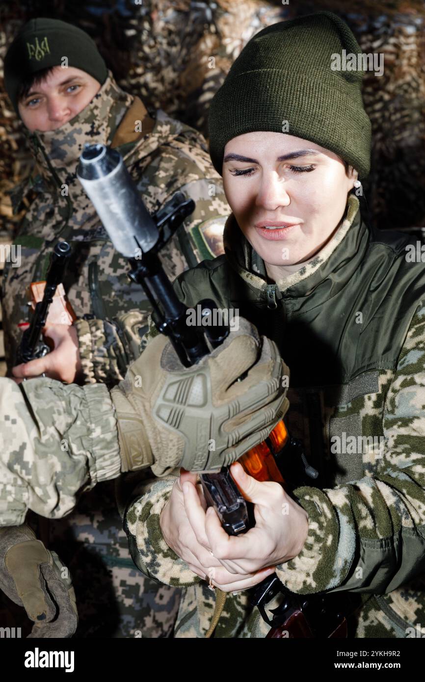 A woman holds an assault rifle during a combat training briefing during ...