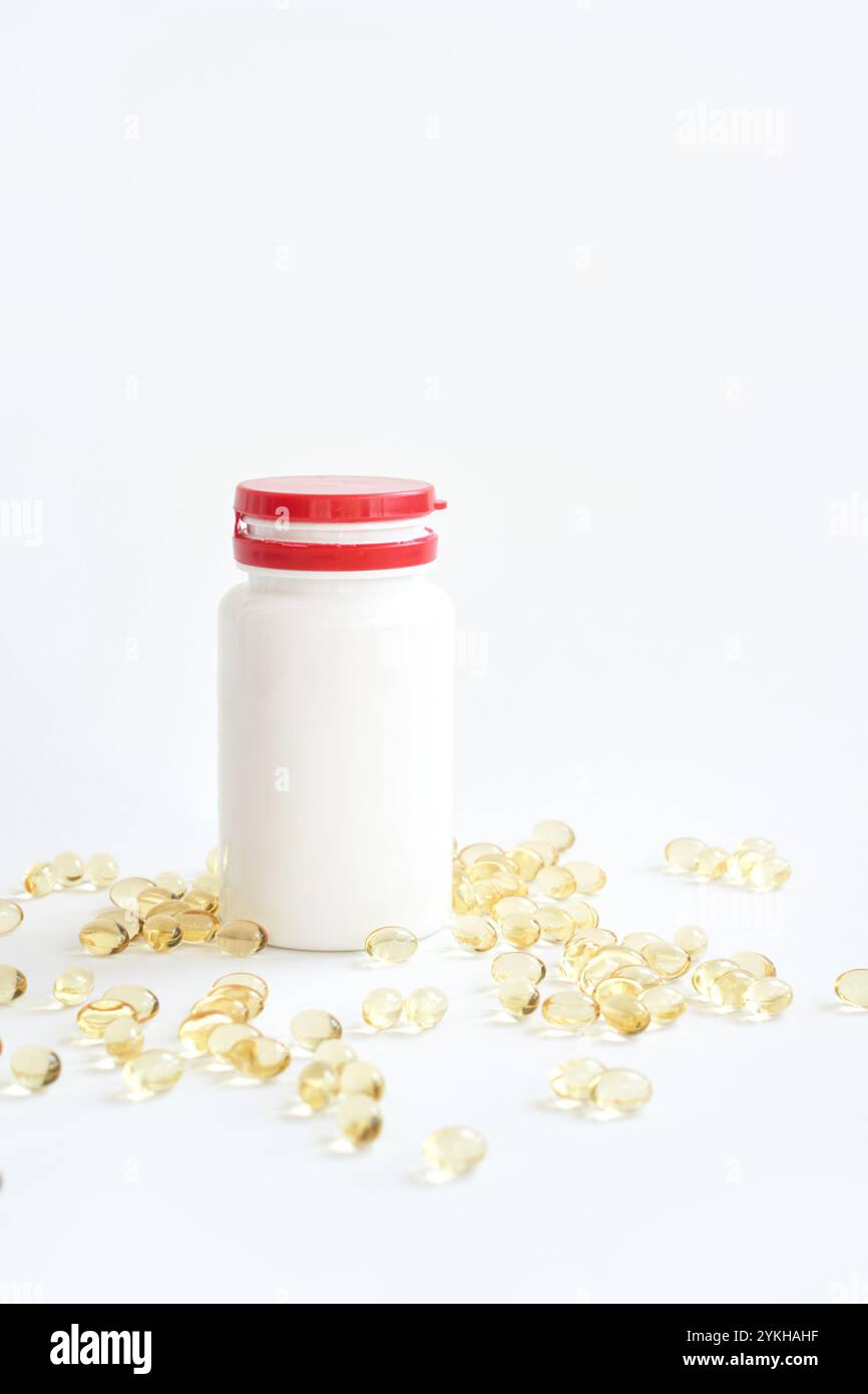 Red cap bottle with white label and scattered yellow capsules isolated ...