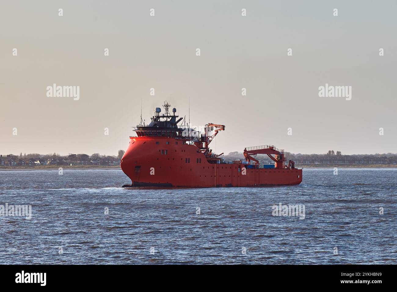 Red offshore support vessel sailing in port on a bright day Stock Photo ...