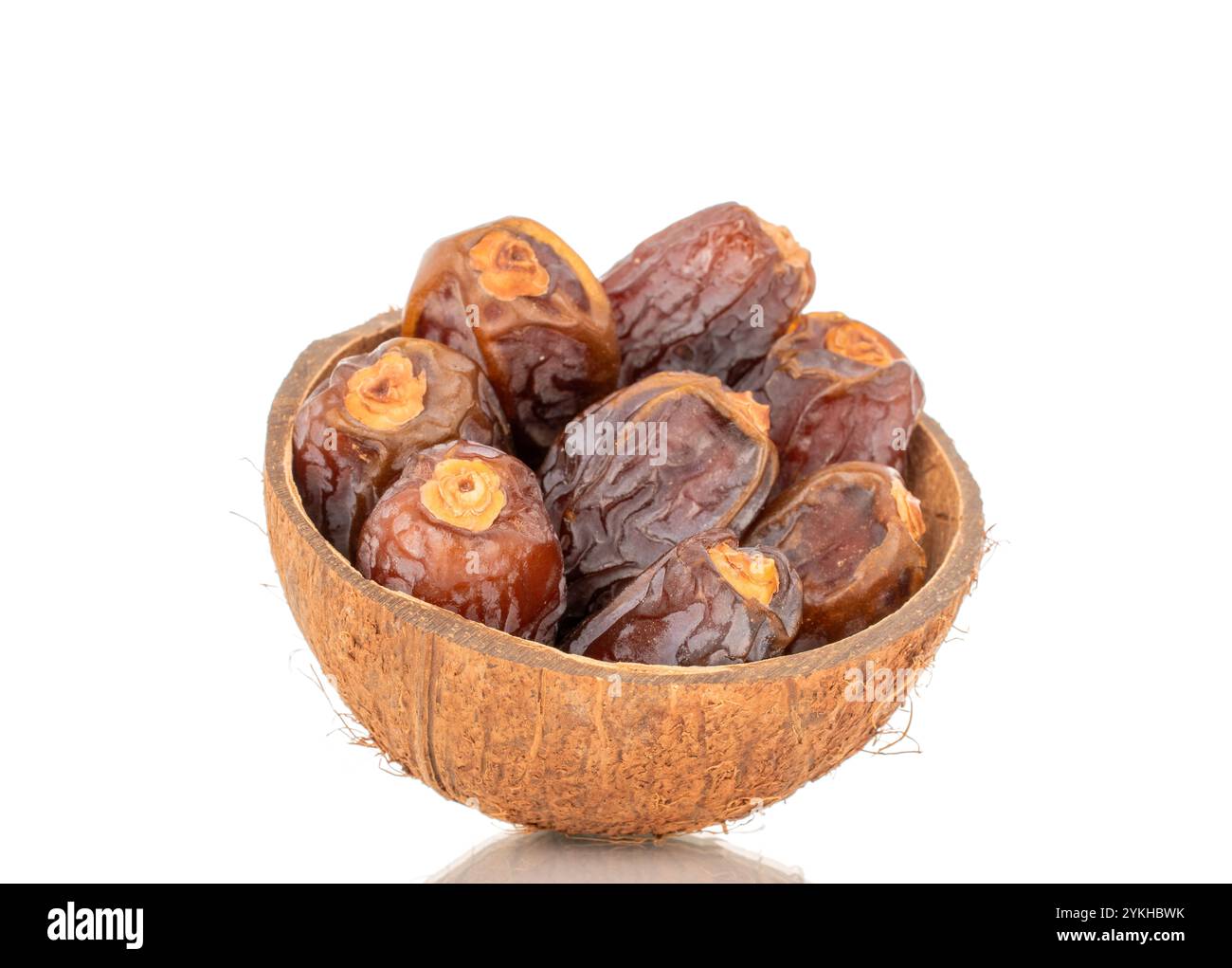 Dried sweet dates in coconut shell, isolated on white background, close ...