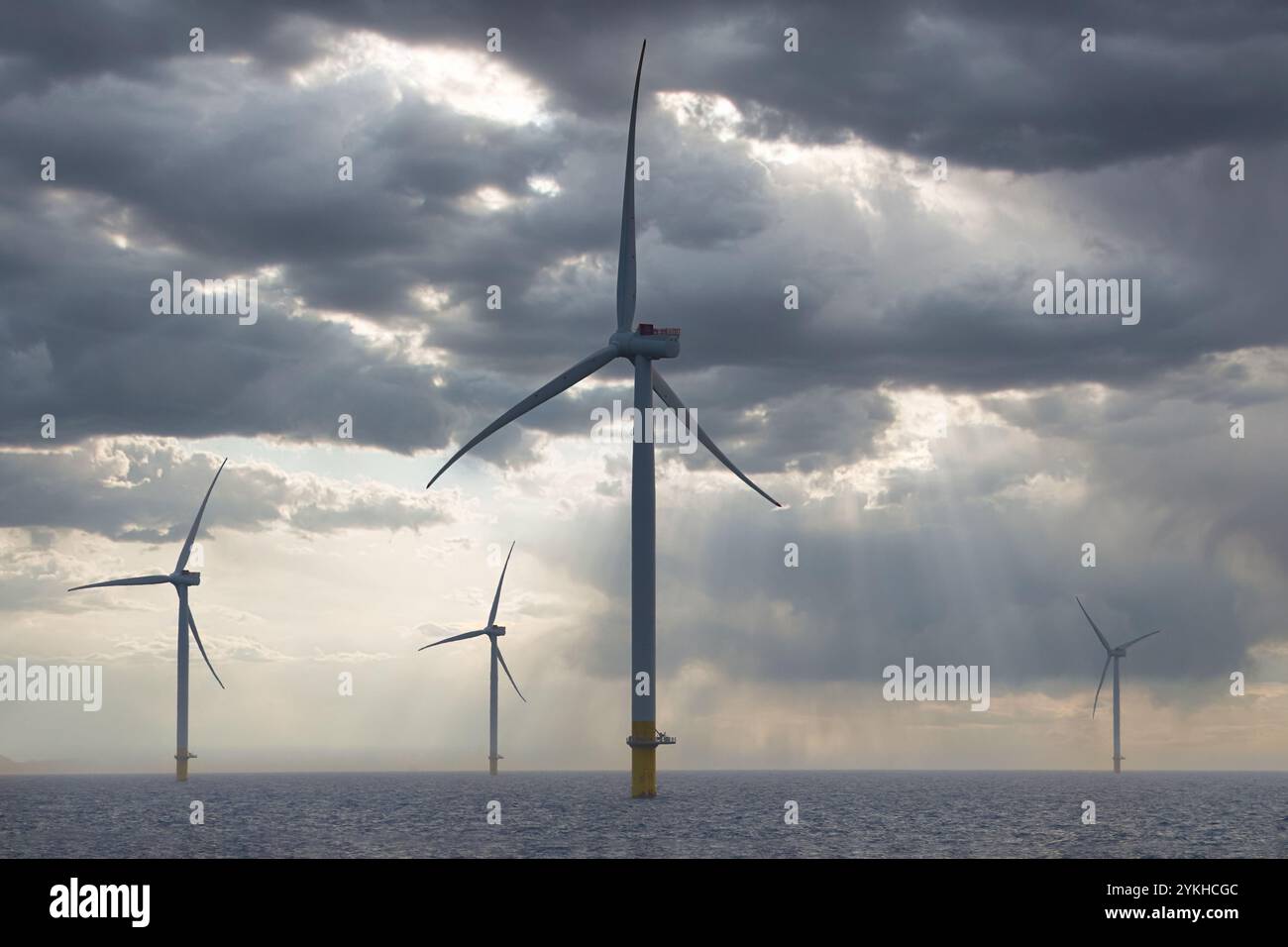 Offshore wind turbines standing in the sea, with grey clouds in the sky ...