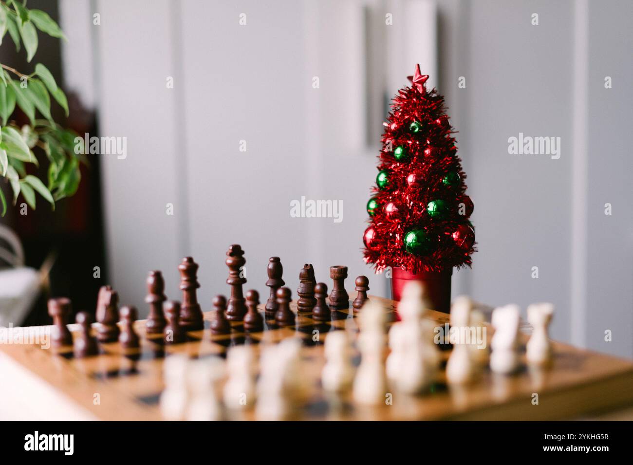 A wooden chess board with pieces on it. The board is on a table and ...