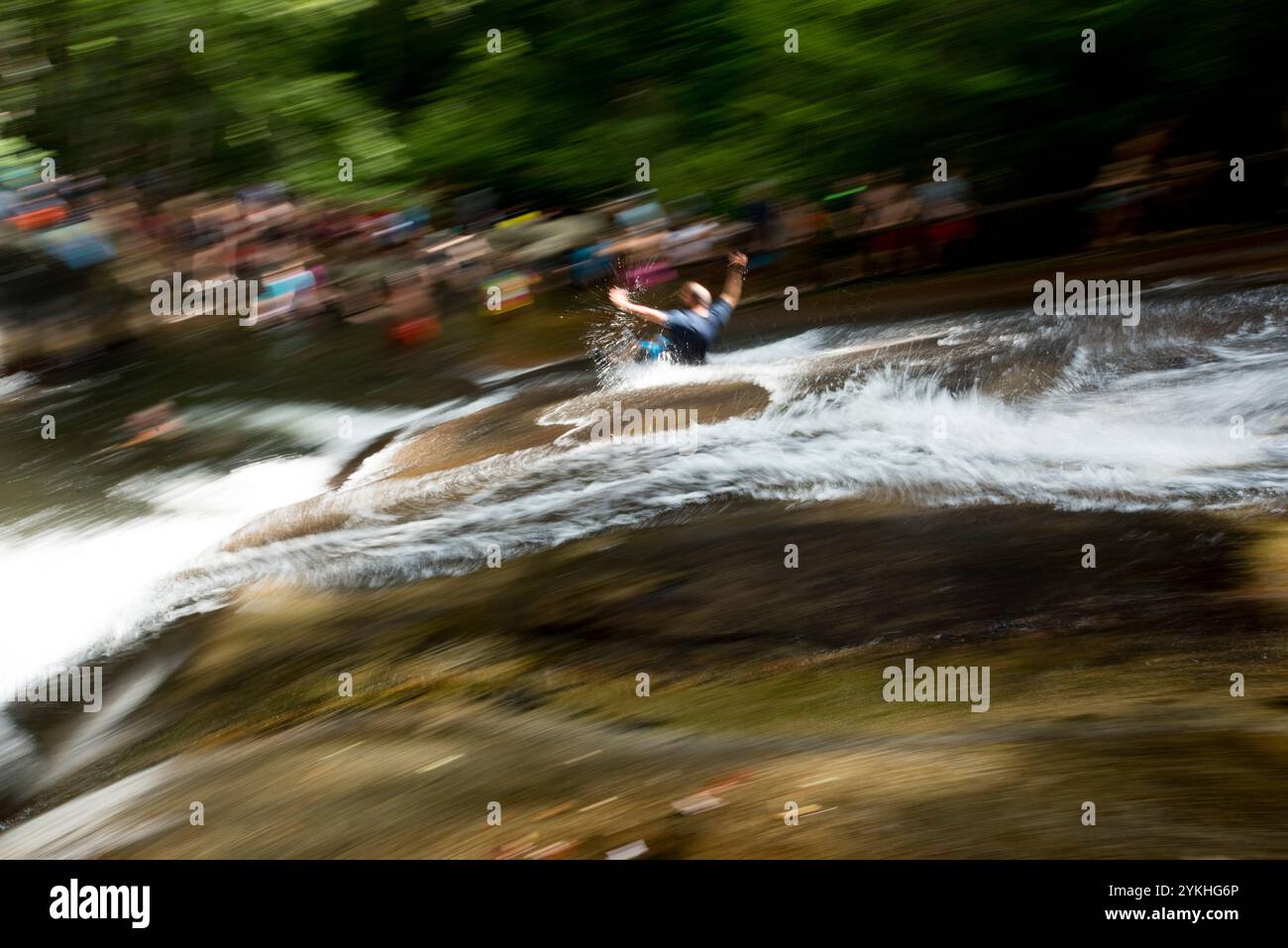 A man slides down the famous Sliding Rock while others watch in the ...