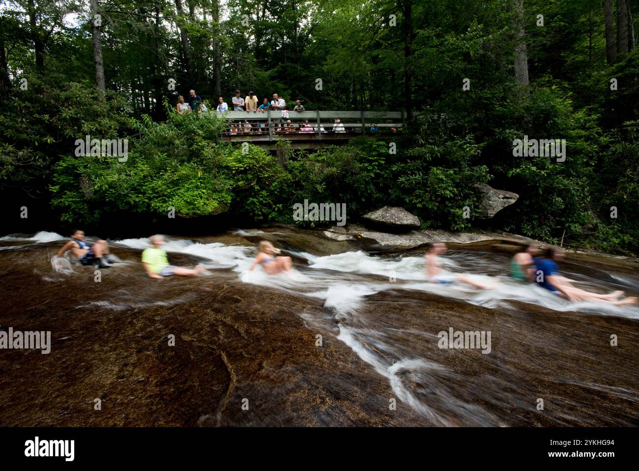 A group of people slide down the famous Sliding Rock while others watch ...